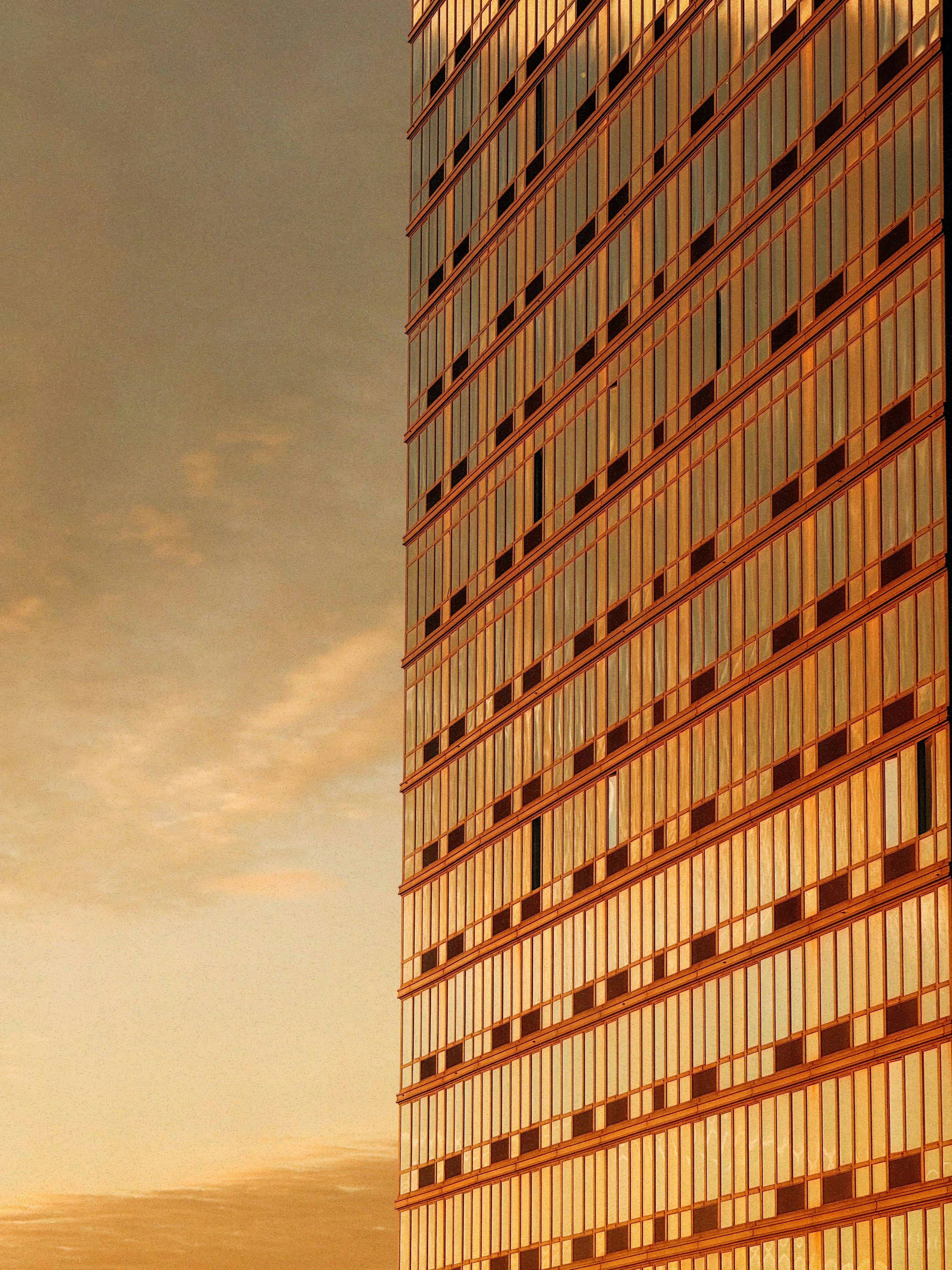 Sunlit Glass Grid: A Tilted Facade Reaching for the Sky