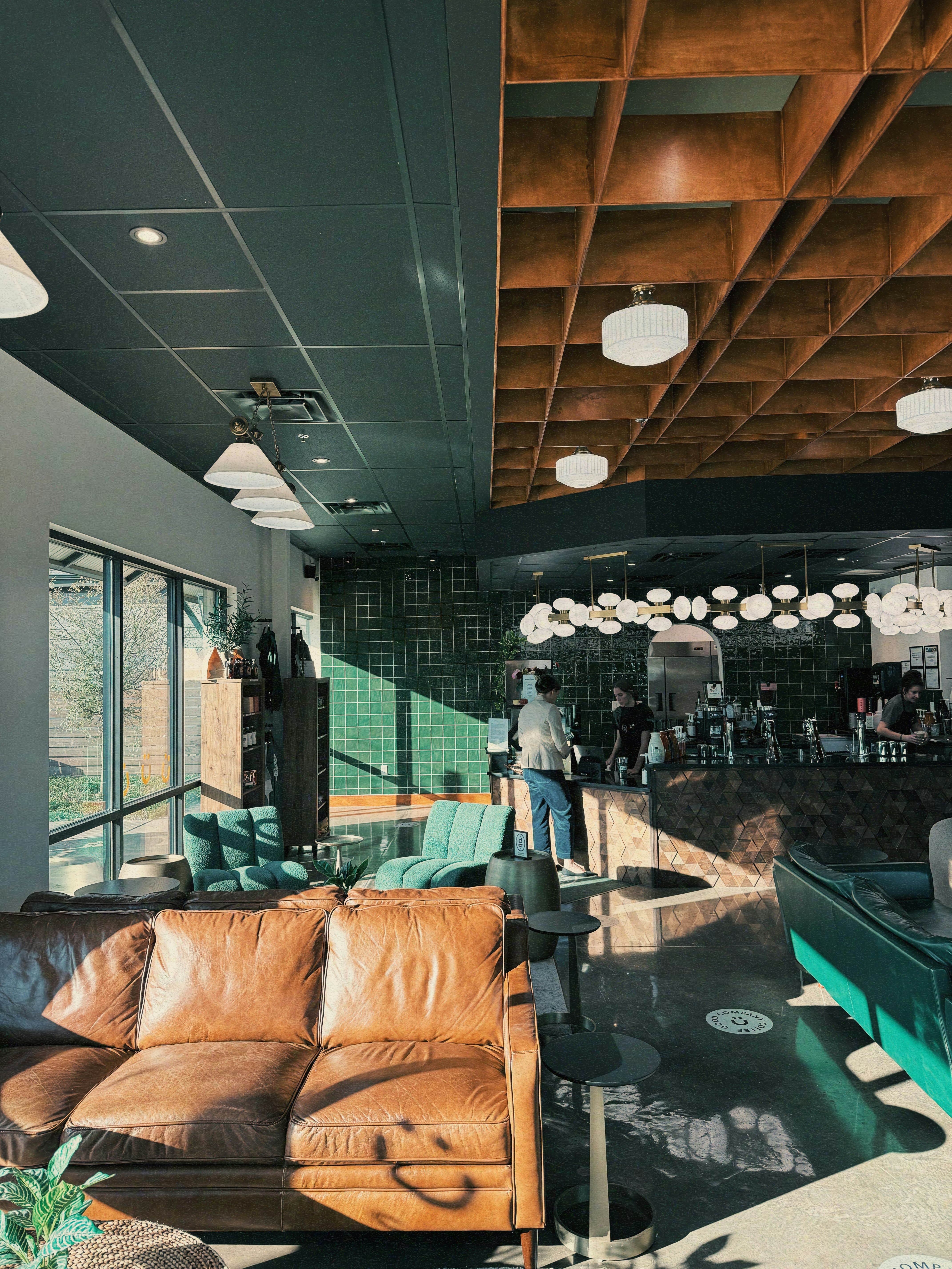 Lounge at Dusk: Sunlit Greens and Leather Comfort in a Modern Café