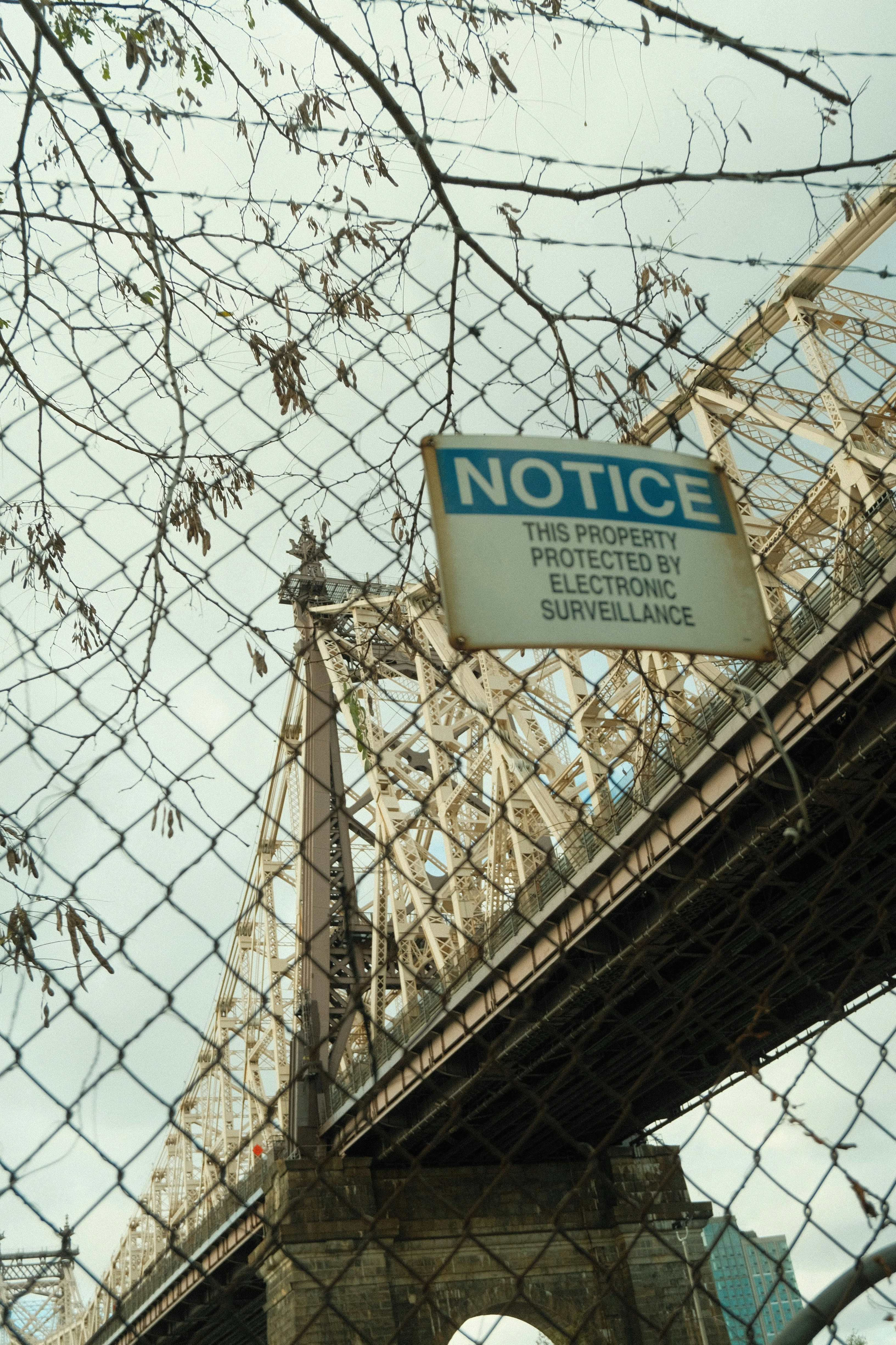 Locked Gate to the Skyline: A Sign Amid the Chain-Link Twilight