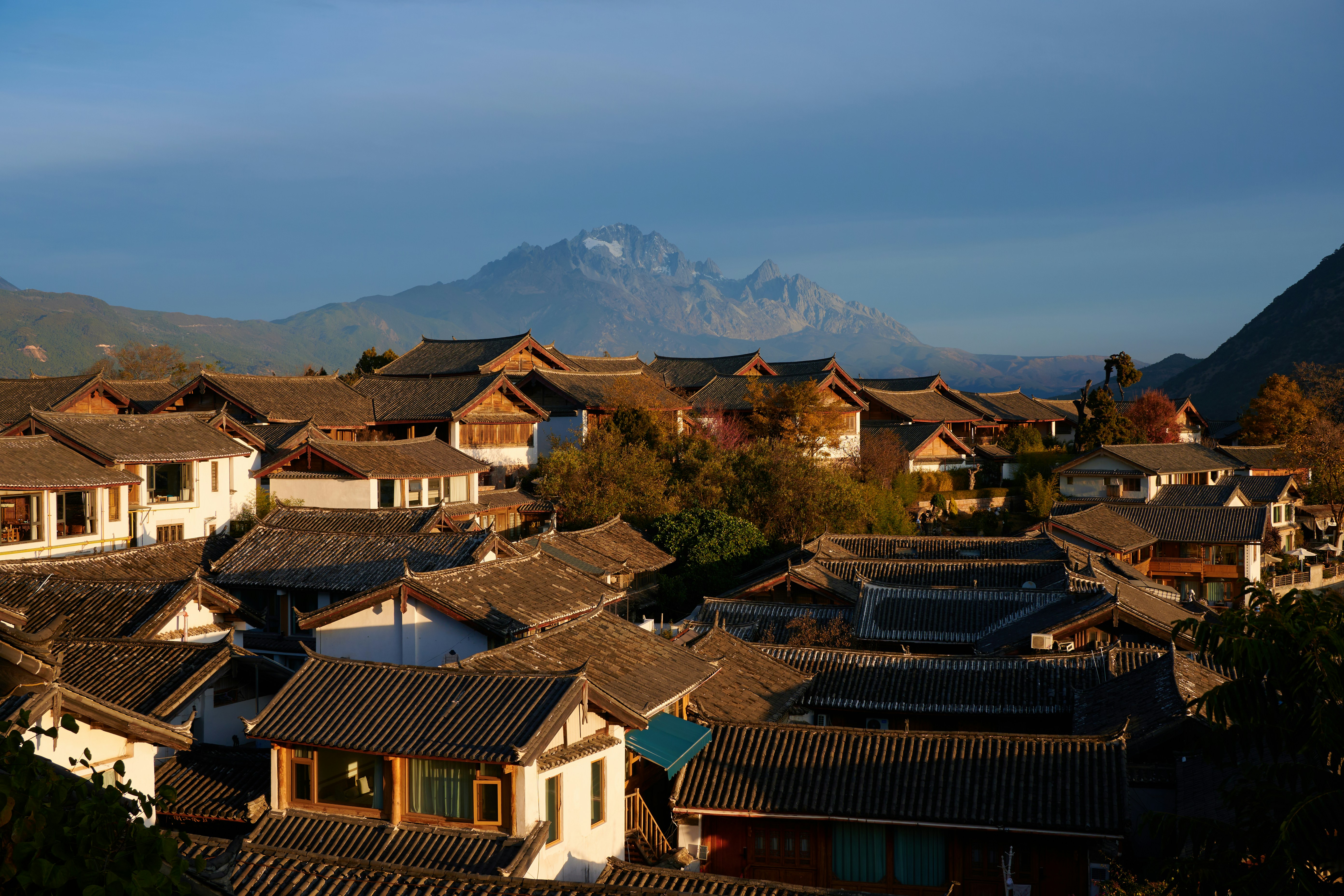 Village of tile-roofed roofs beneath a distant alpine ridge
