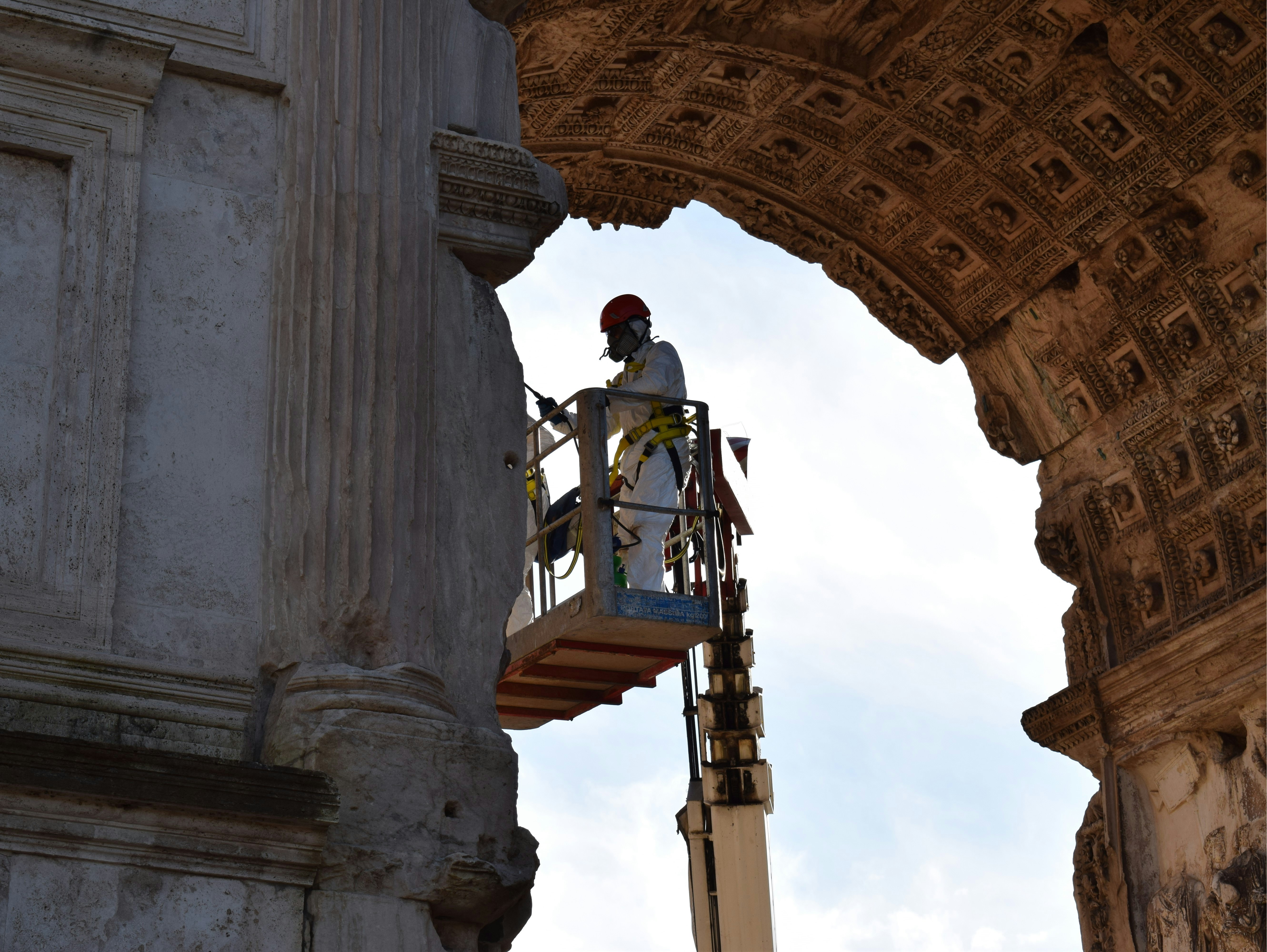 Crane Against Carved Arch: A Climber at the Edge of History