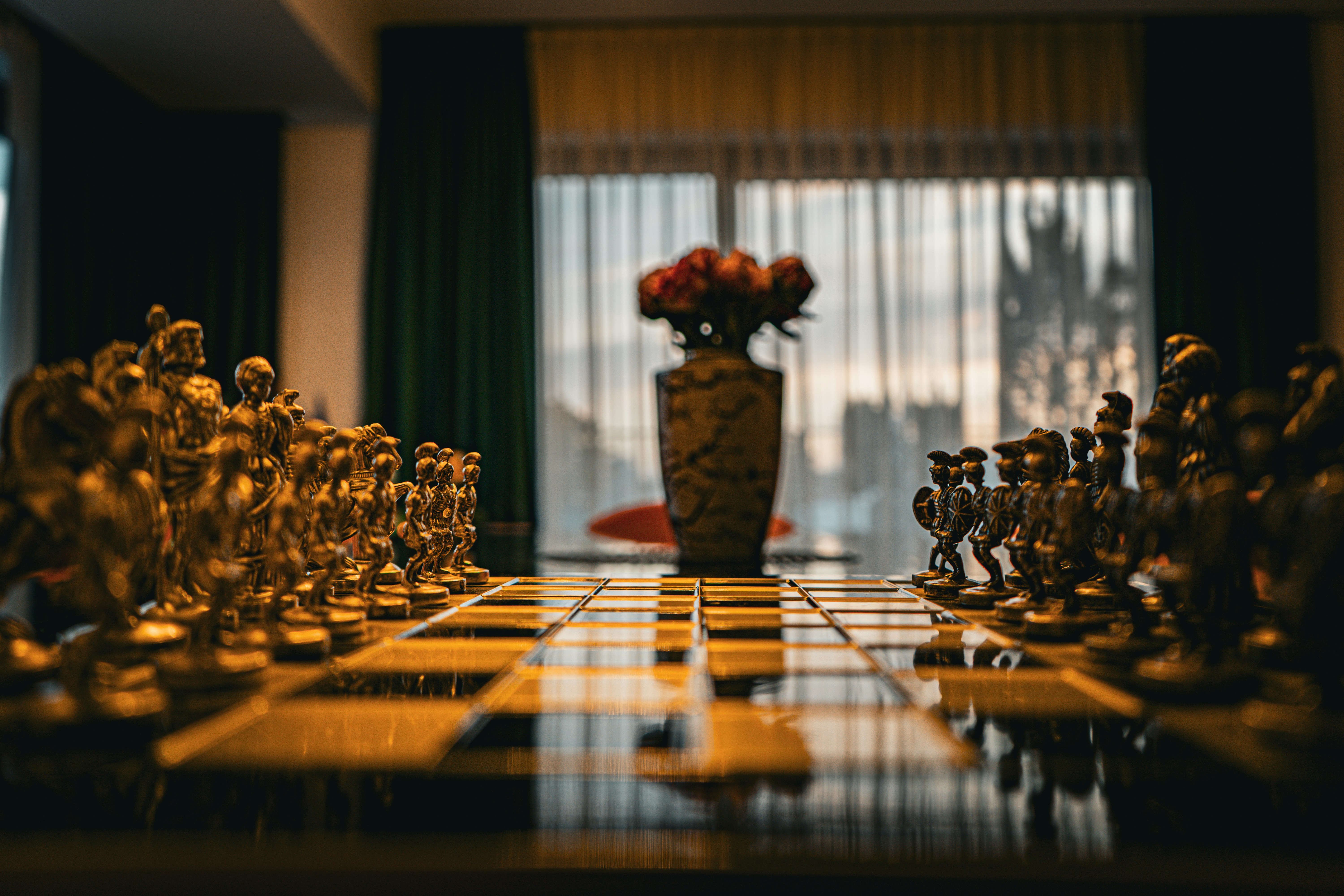 A Quiet Duel: Chessboard in Focus as Florals Framed by Window Light