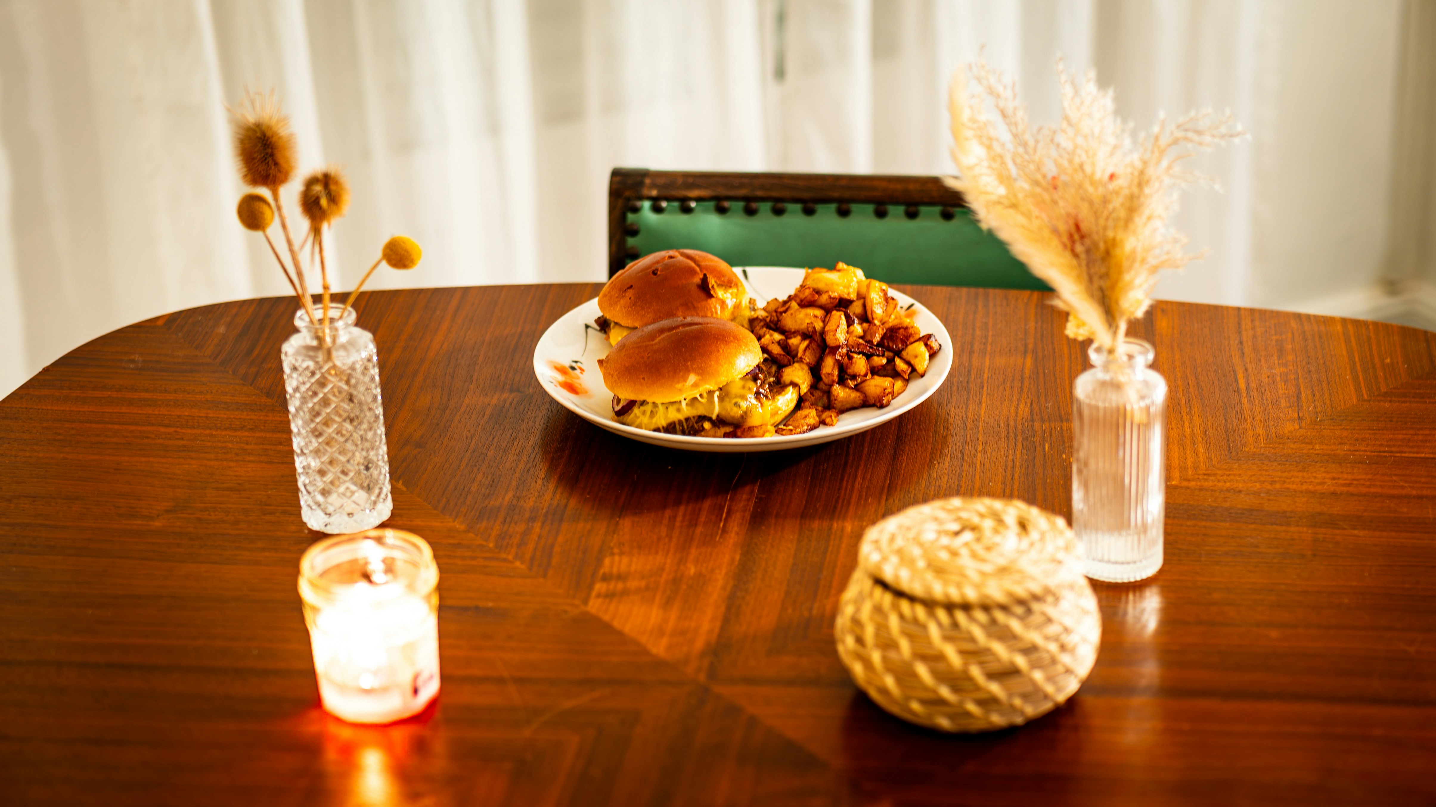Tabletop Feast: A Cozy Arrangement of Burgers, Fries, and Warm Candlelight