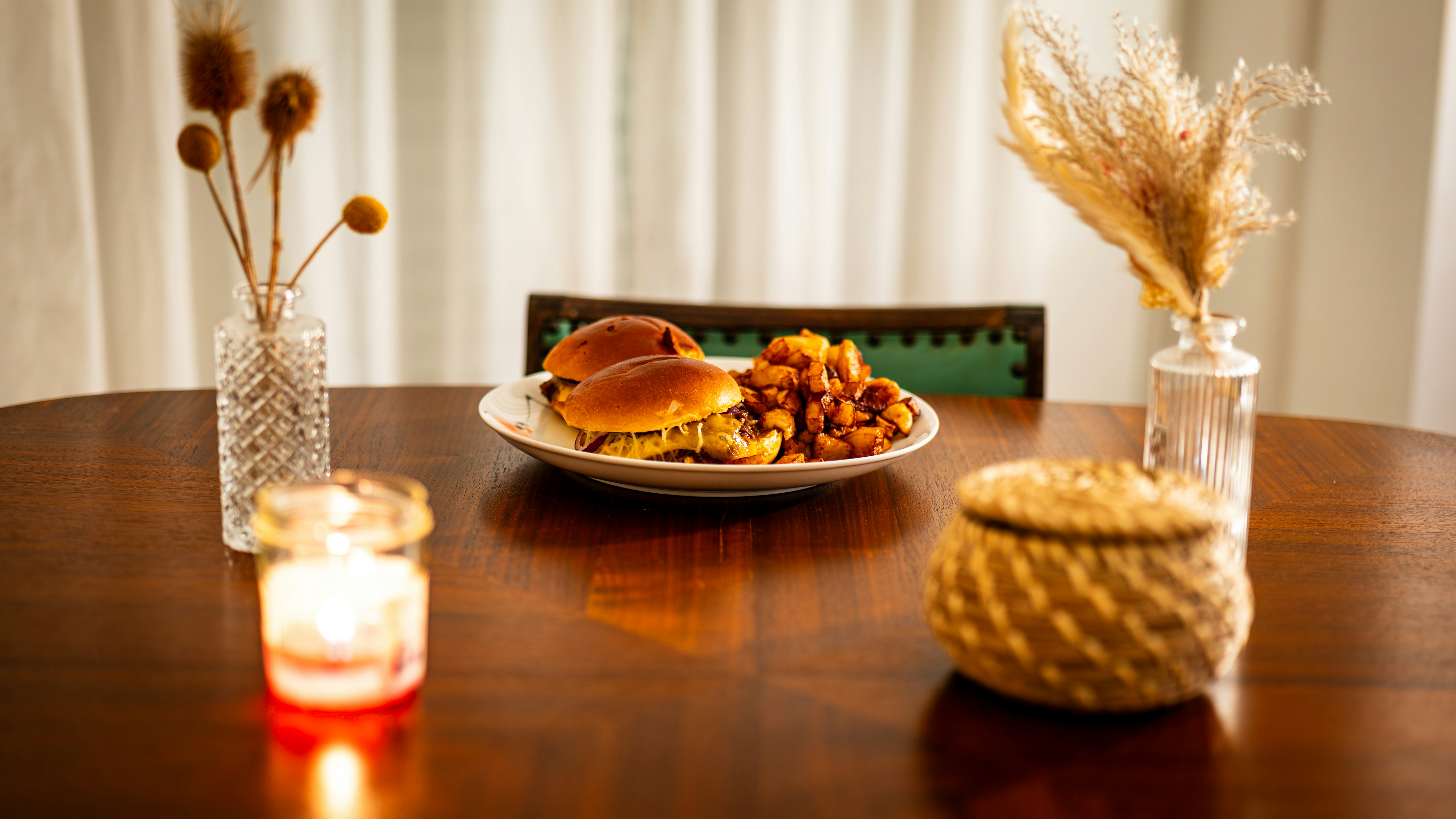 Warm Table Centerpiece: A Plate of Burgers and Crispy Sides Framed by Dried Florals