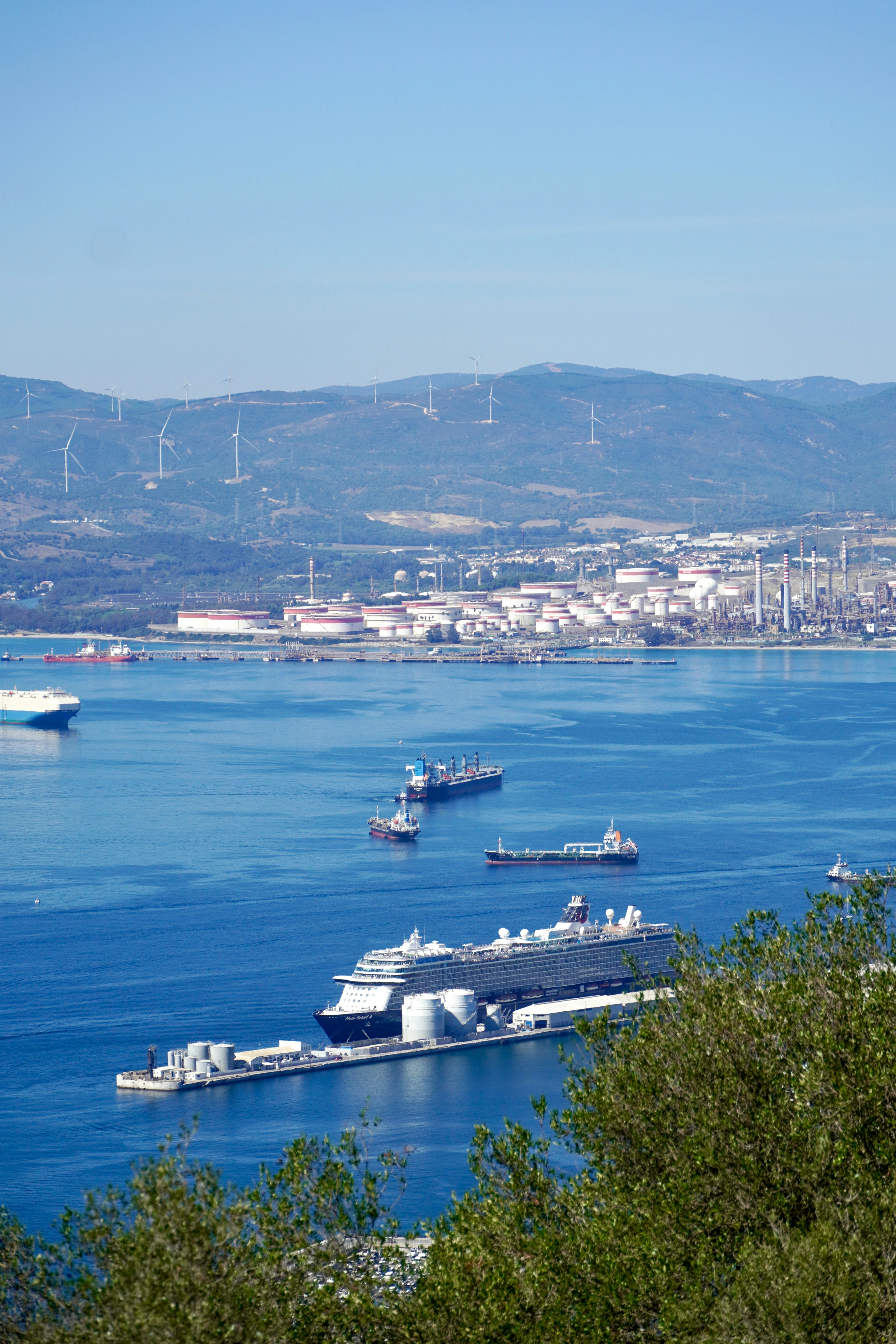 Quiet Harbor: A Lineup of Ships Nestled Against an Industrial Coast