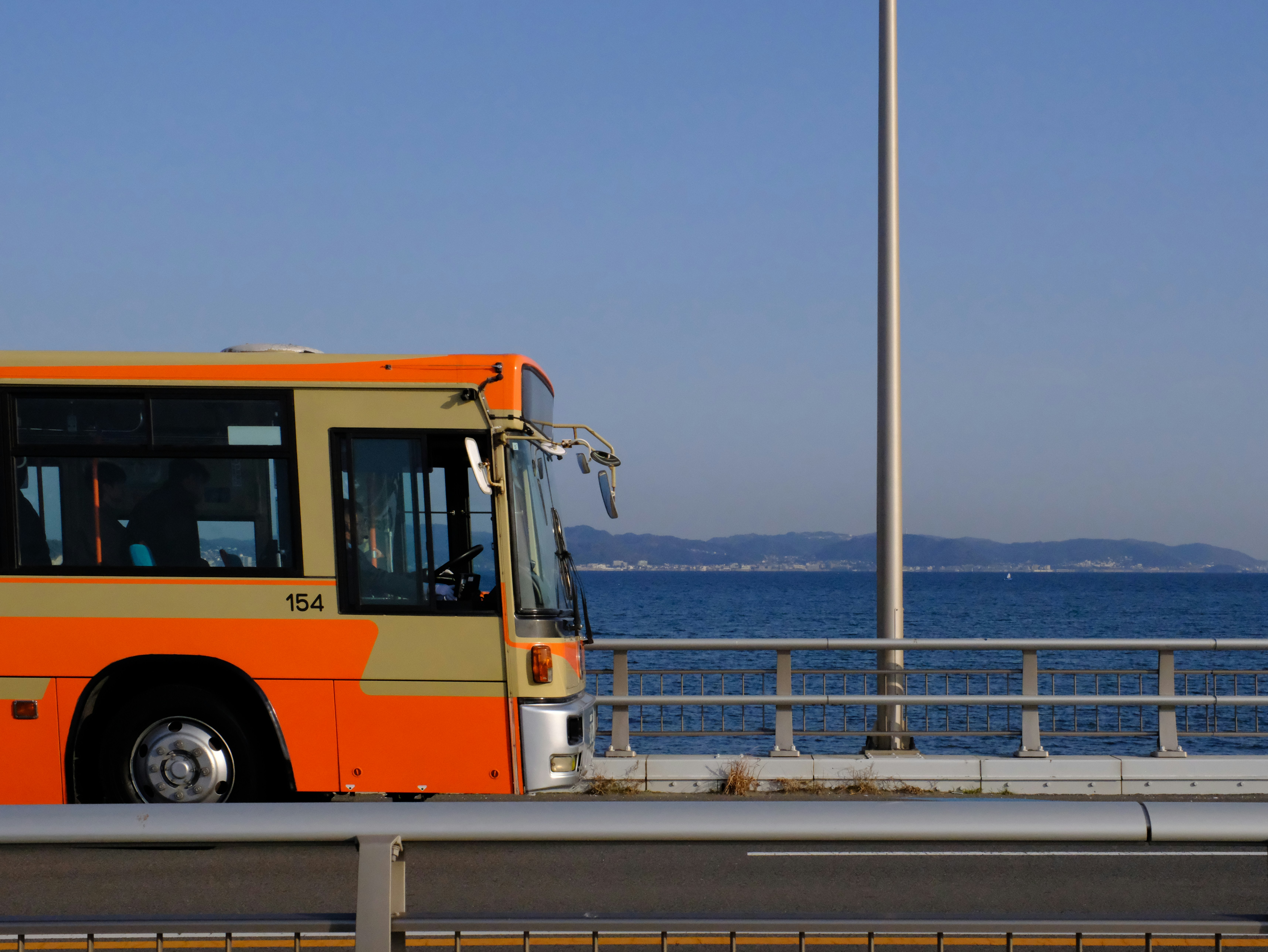 Orange Bus on a Seaside Promenade