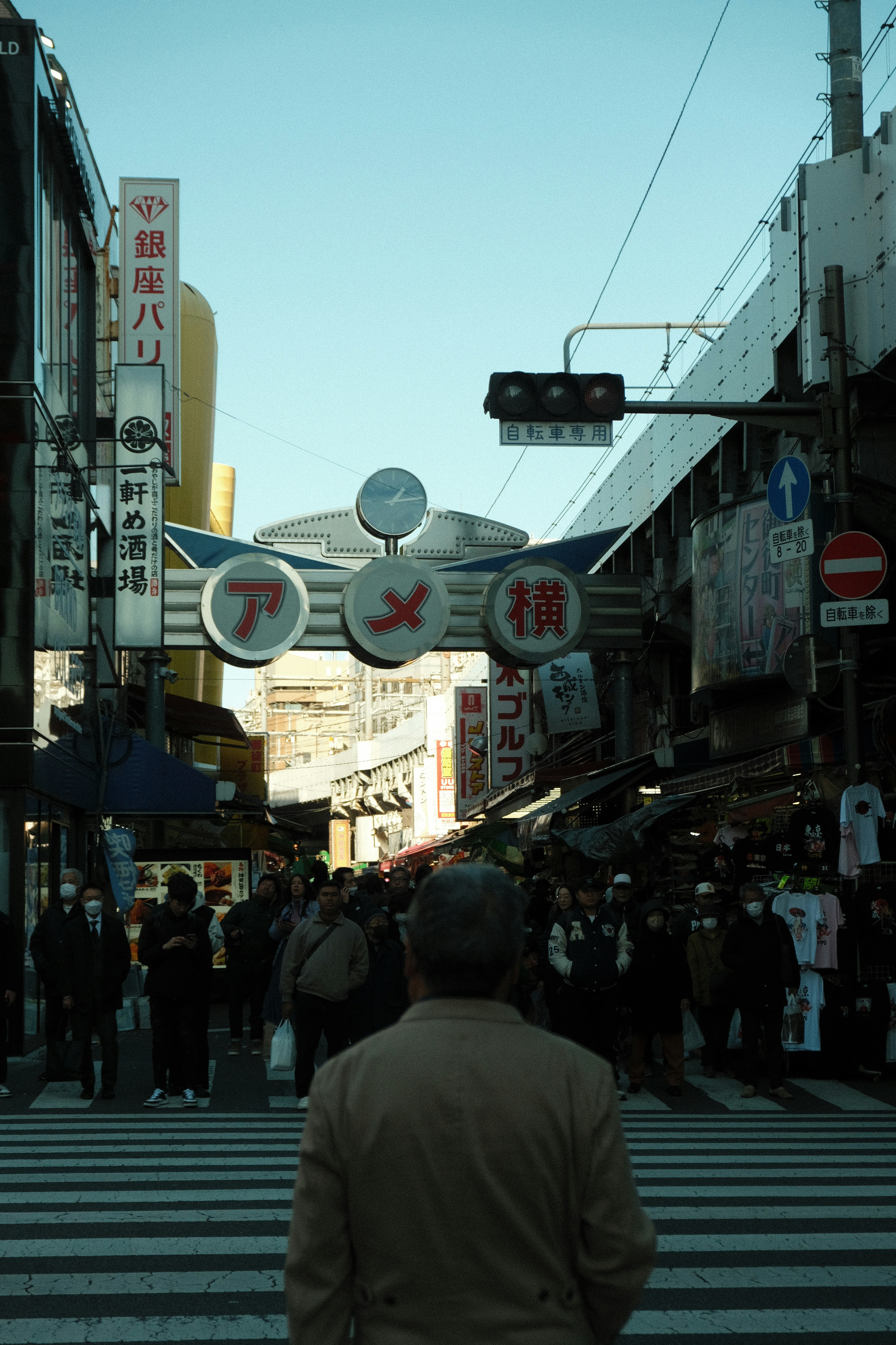 Street Crossing beneath Neon Arches in a Bustling Japanese Market