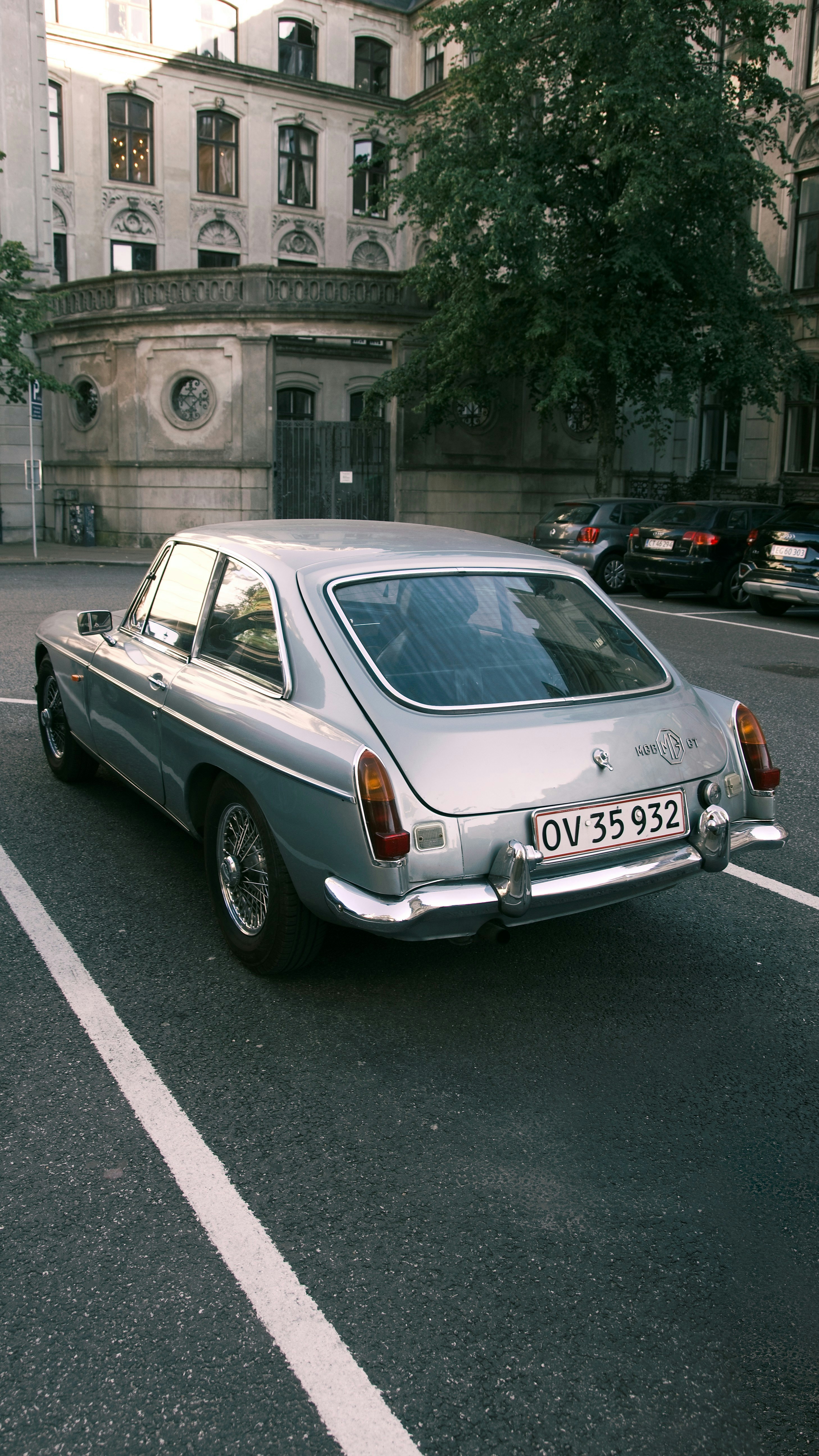Silver Classic Seduction: A Vintage Rover Rests in an Urban Courtyard