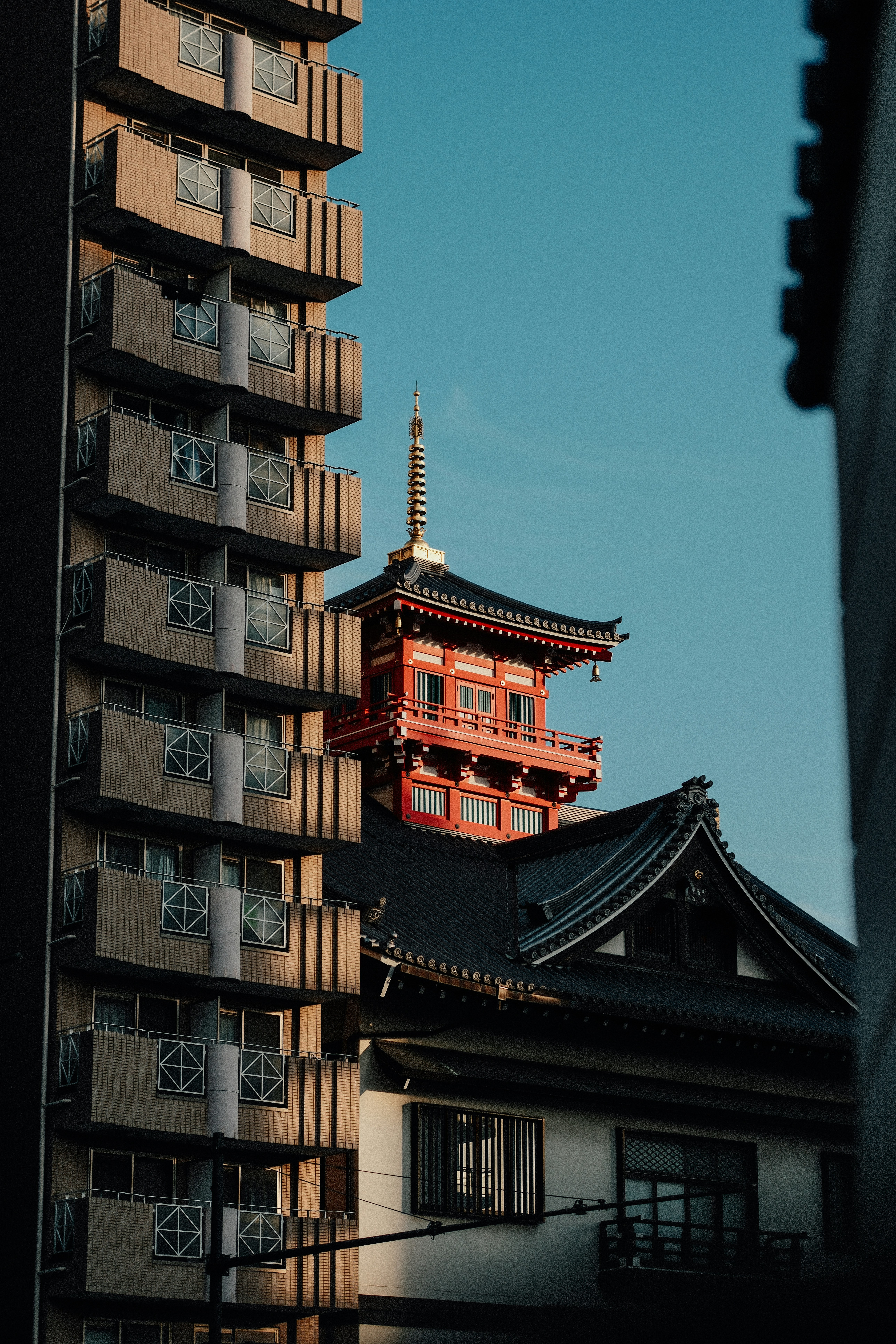 Contrasting Horizons: Modern Flats Meet a Crimson Pagoda