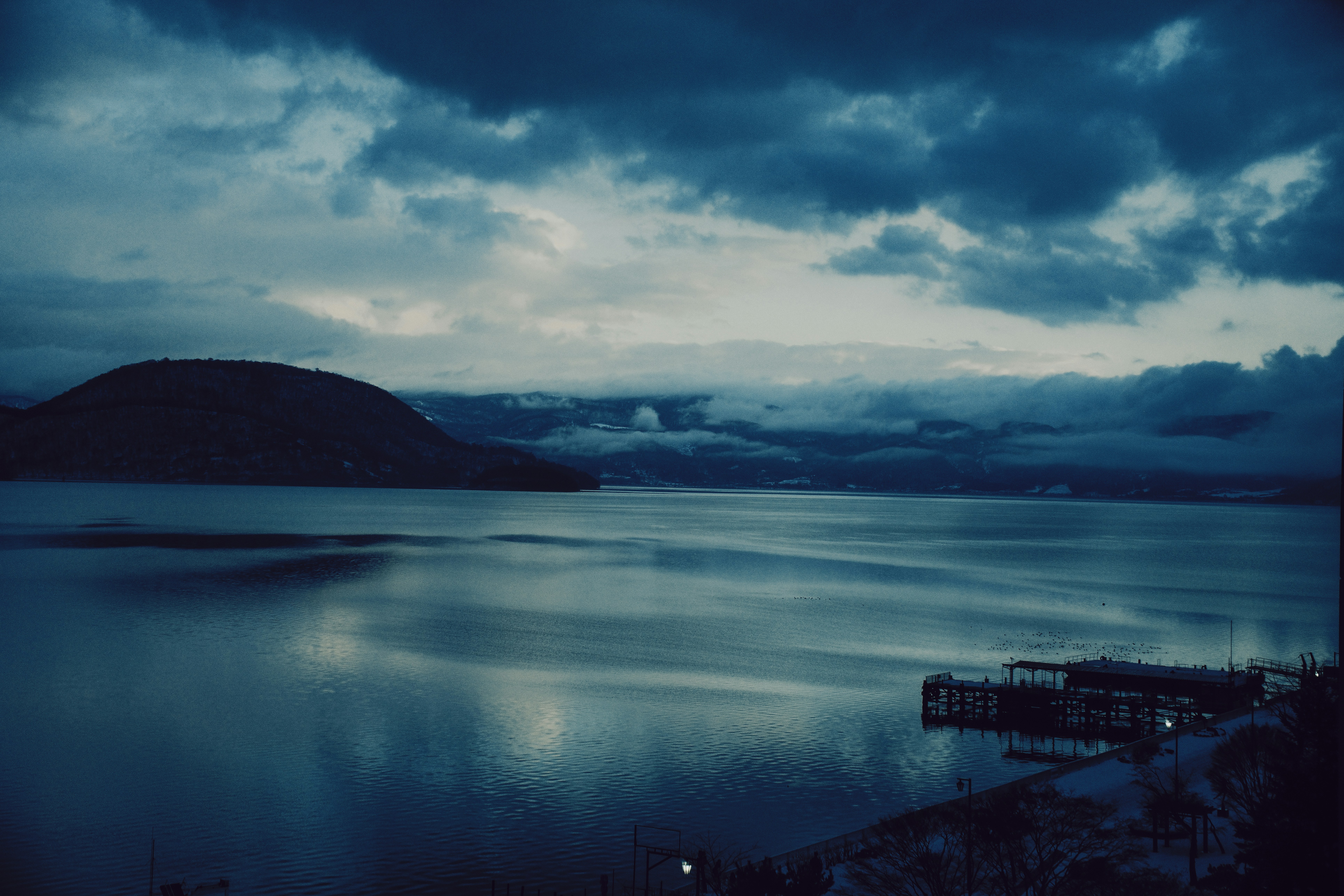 Twilight Dunes: A Quiet Waterfront Under Stormy Blue Skies
