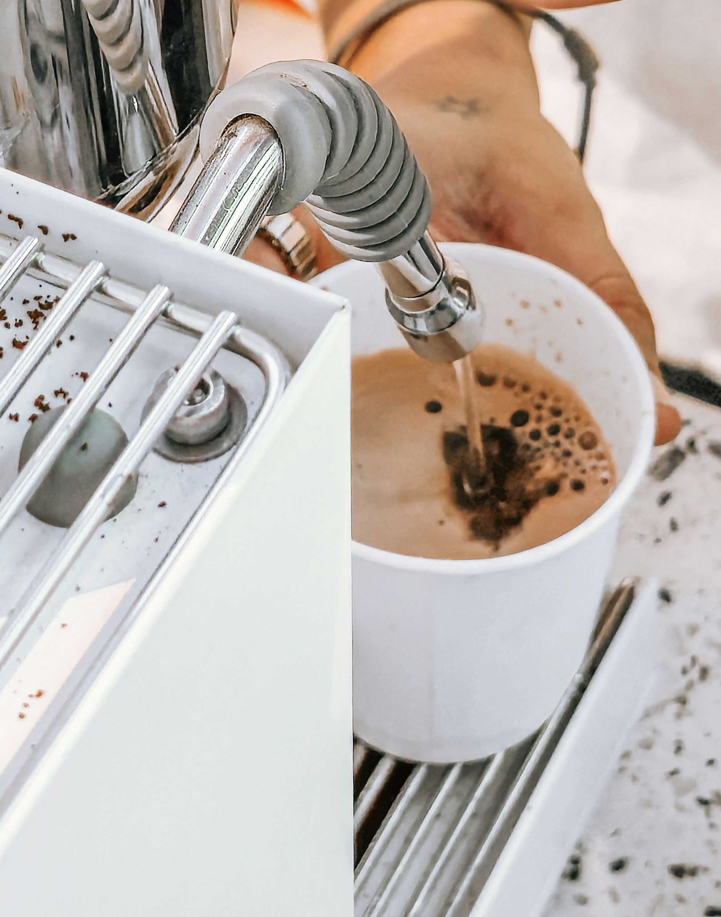 Brew in Focus: Barista’s Hand Steadies the Espresso Pour