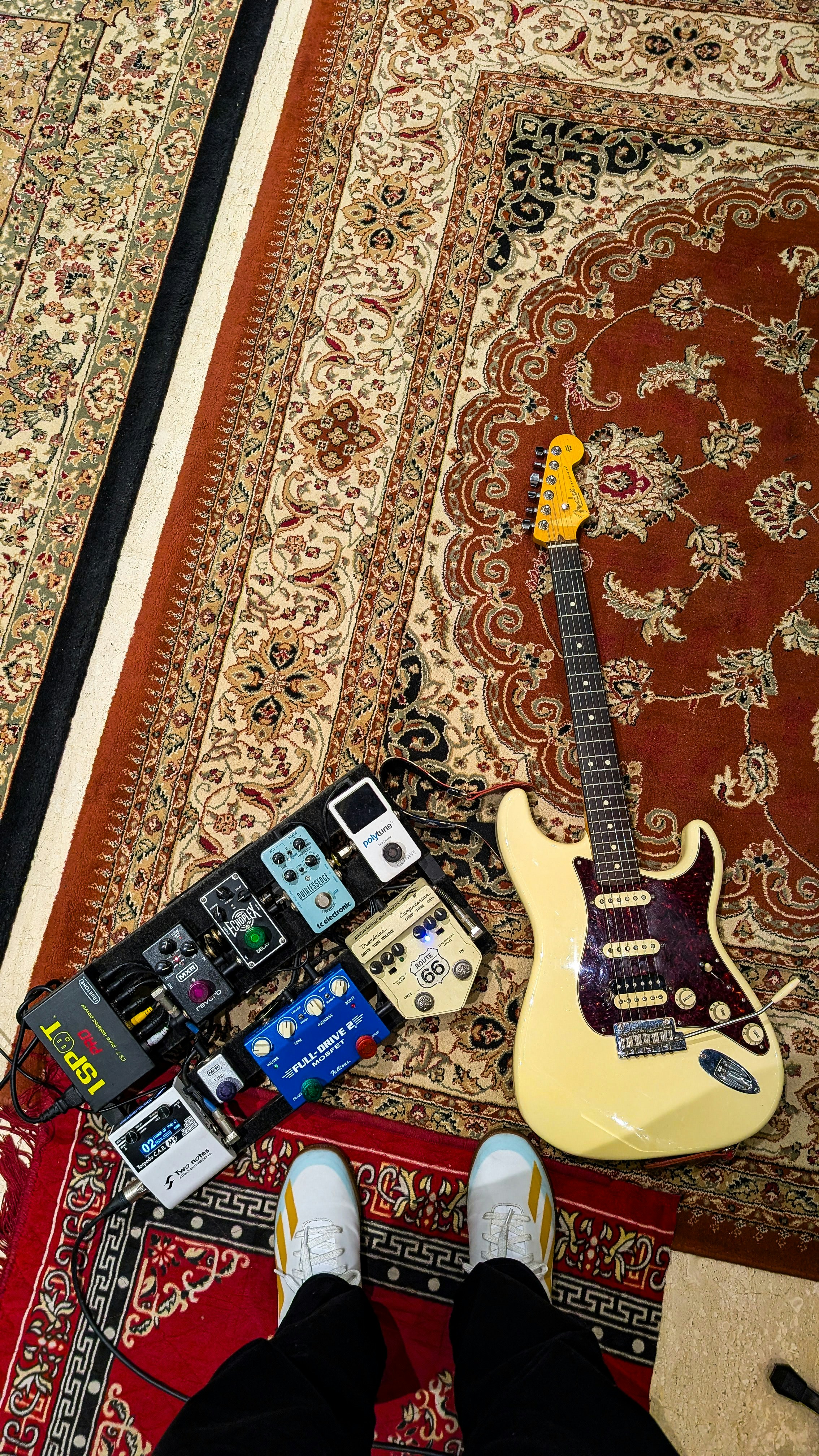 Electric guitar and pedals on a patterned rug