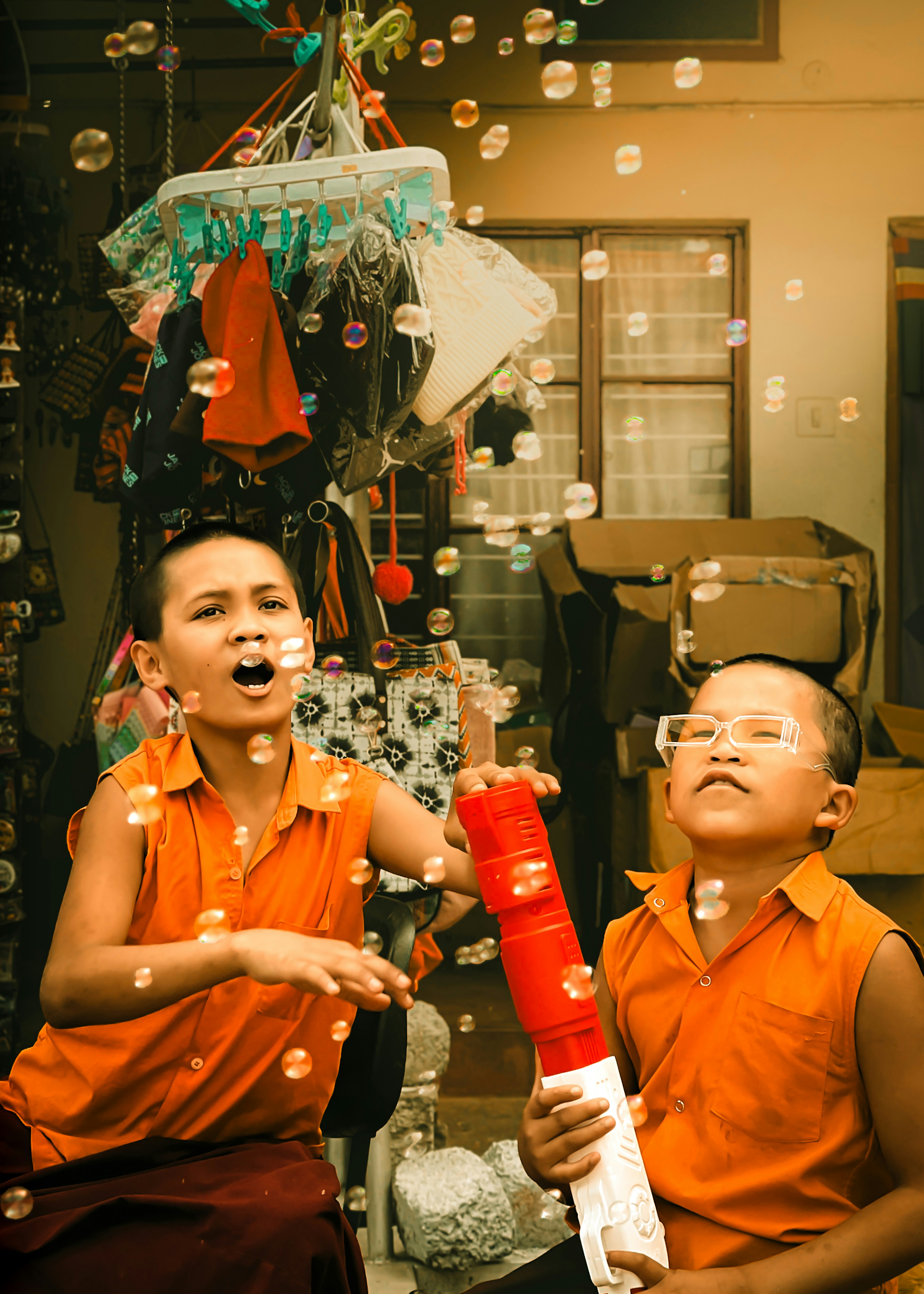 Two Orange-Clad Friends Sparking Soap Bubbles in a Cluttered Courtyard