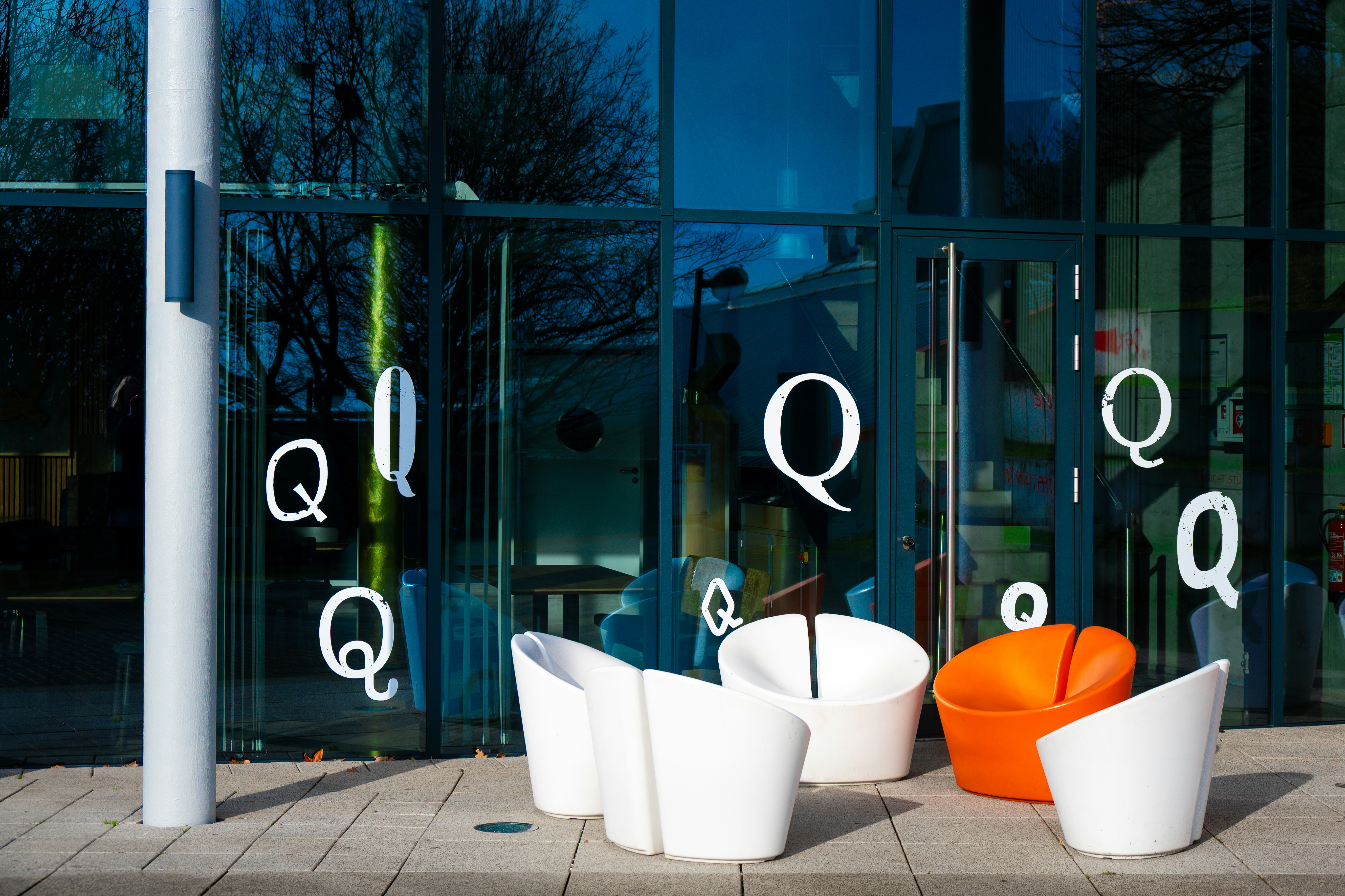 Glass Facade with Floating Qs and Seating Oasis