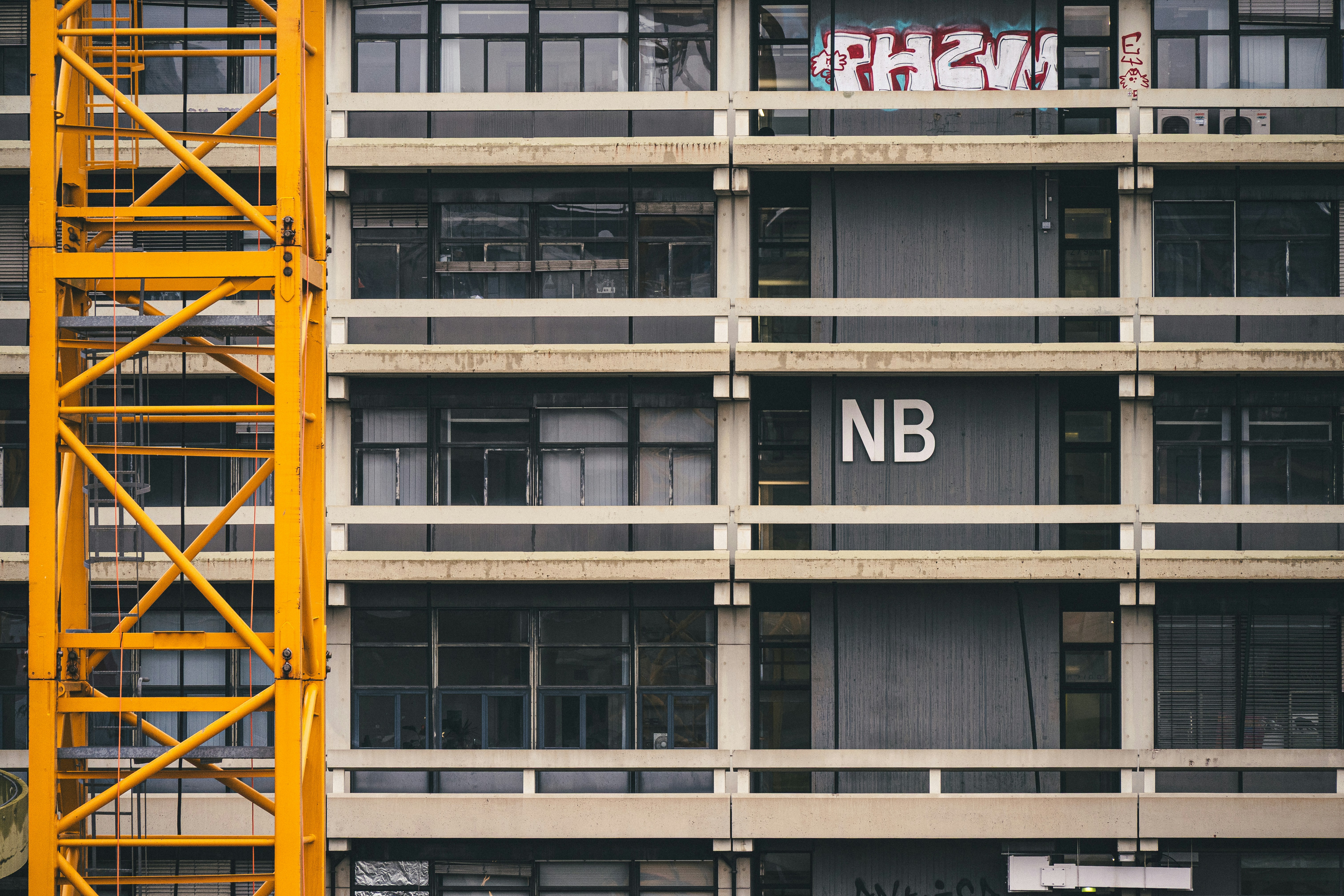 Urban scaffold silhouette: NB sign amid a grid of concrete and glass