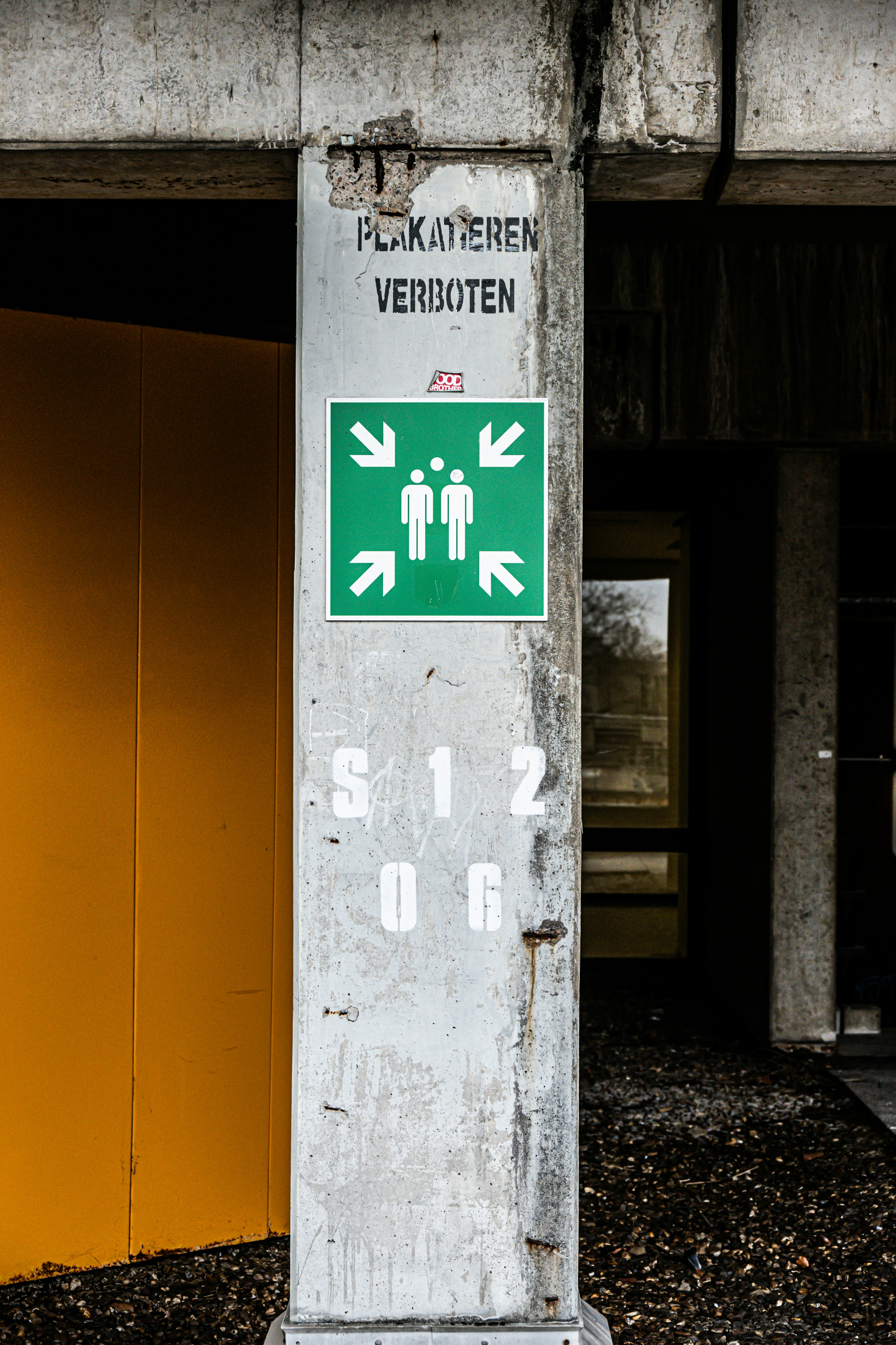 Urban Resilience: A Weathered Column and Safety Sign in a Deserted Structure