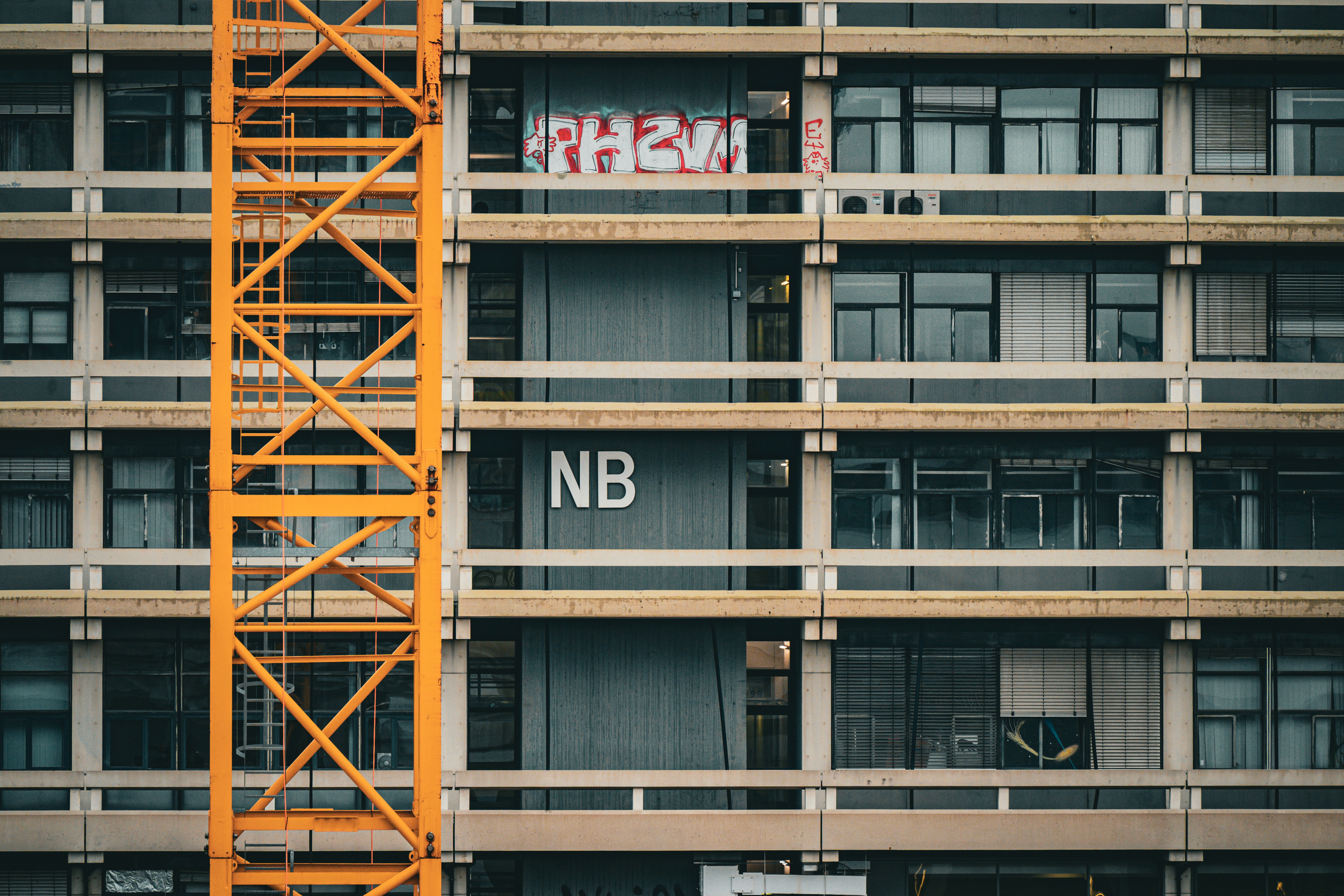Concrete Grid and Bright Crane: Vertical Lines Meet an Orange Beam