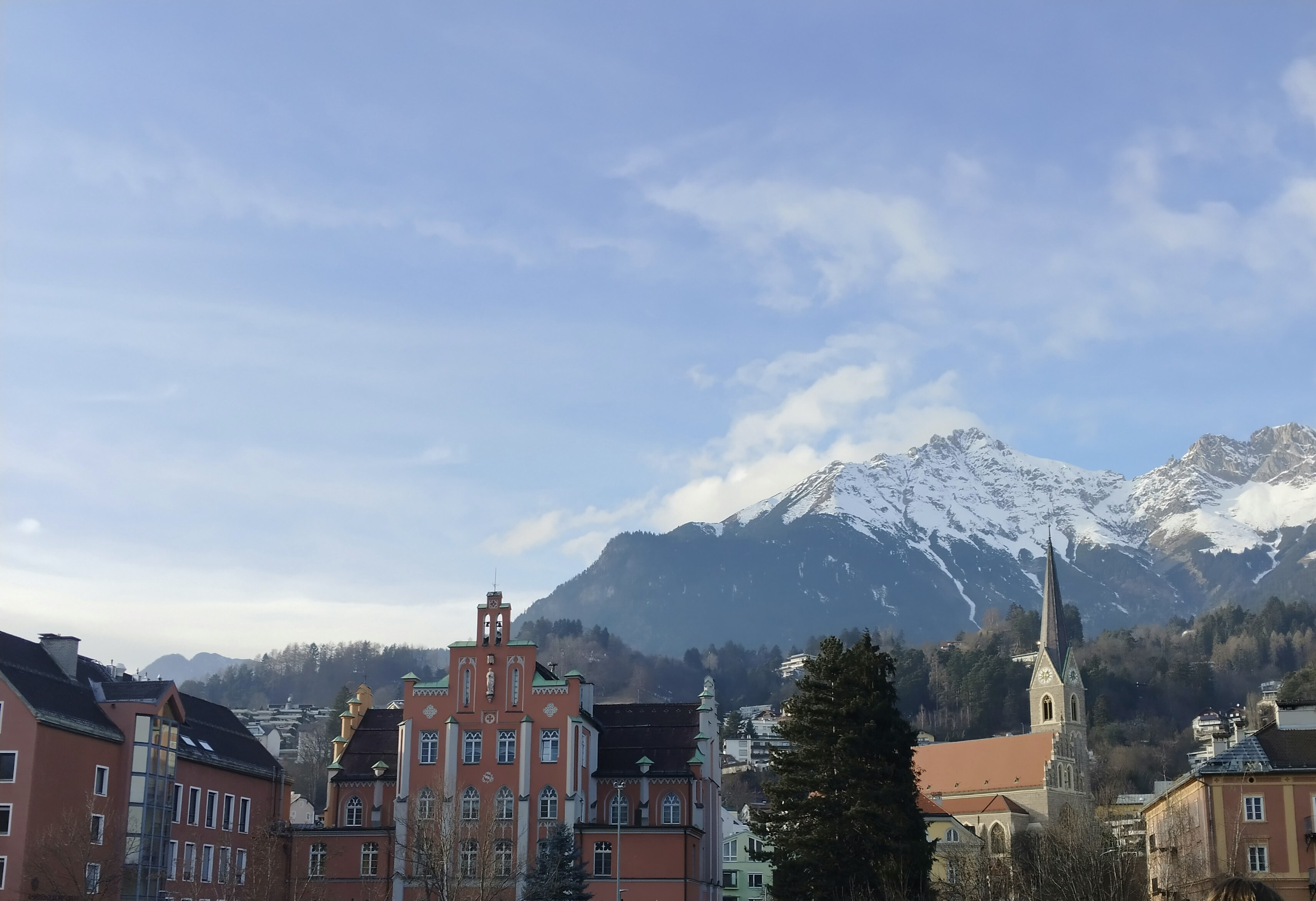 Snow-capped Alps silhouette over a colorful European town