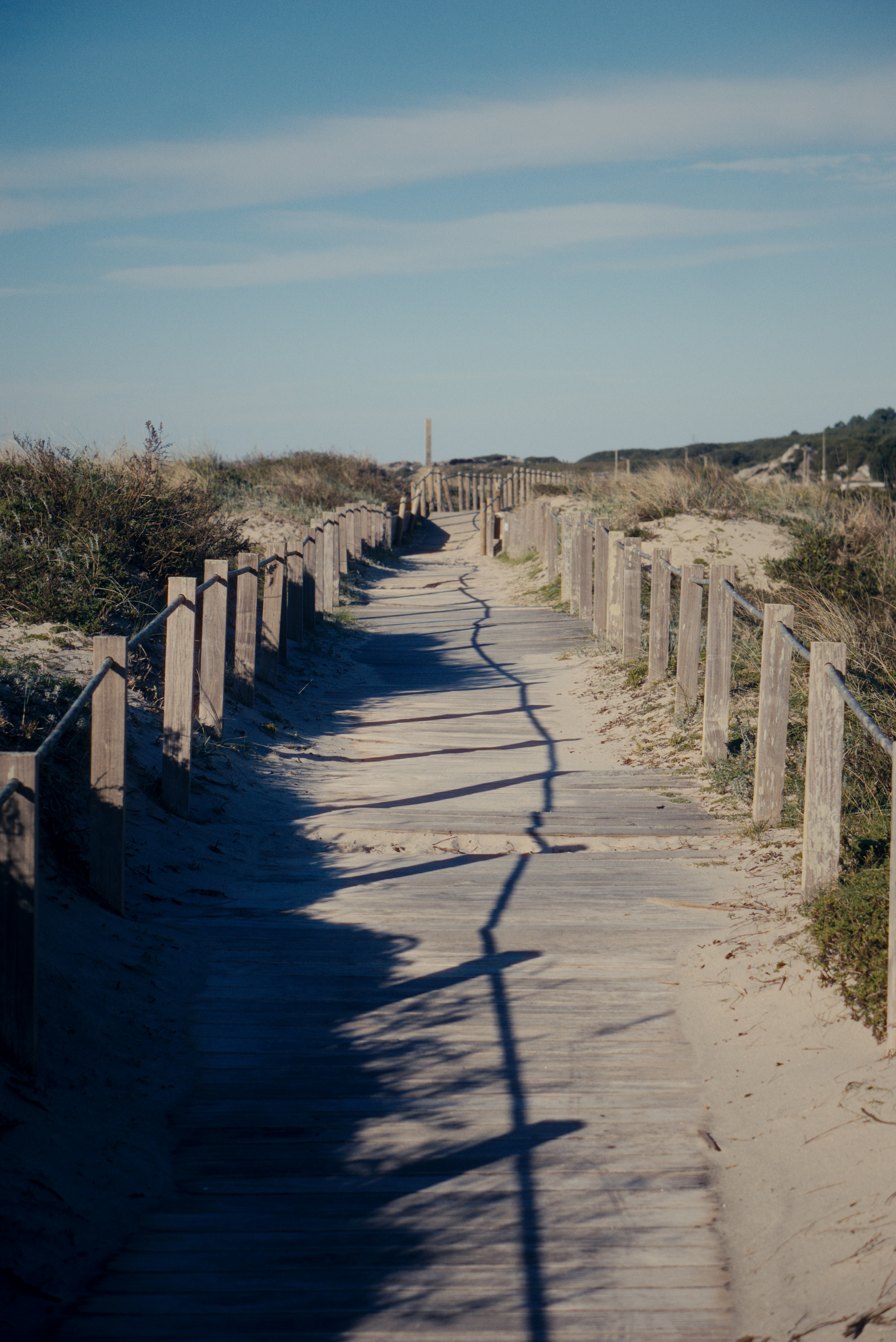 Path Through the Dunes: A Weathered Boardwalk into the Horizon