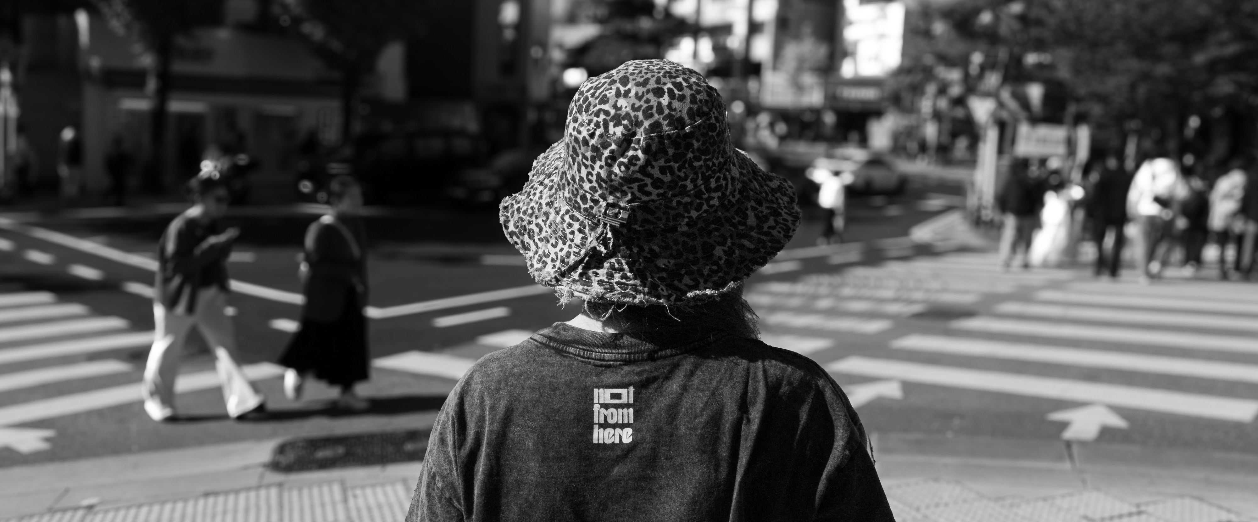 Person wearing a textured hat crosses a street