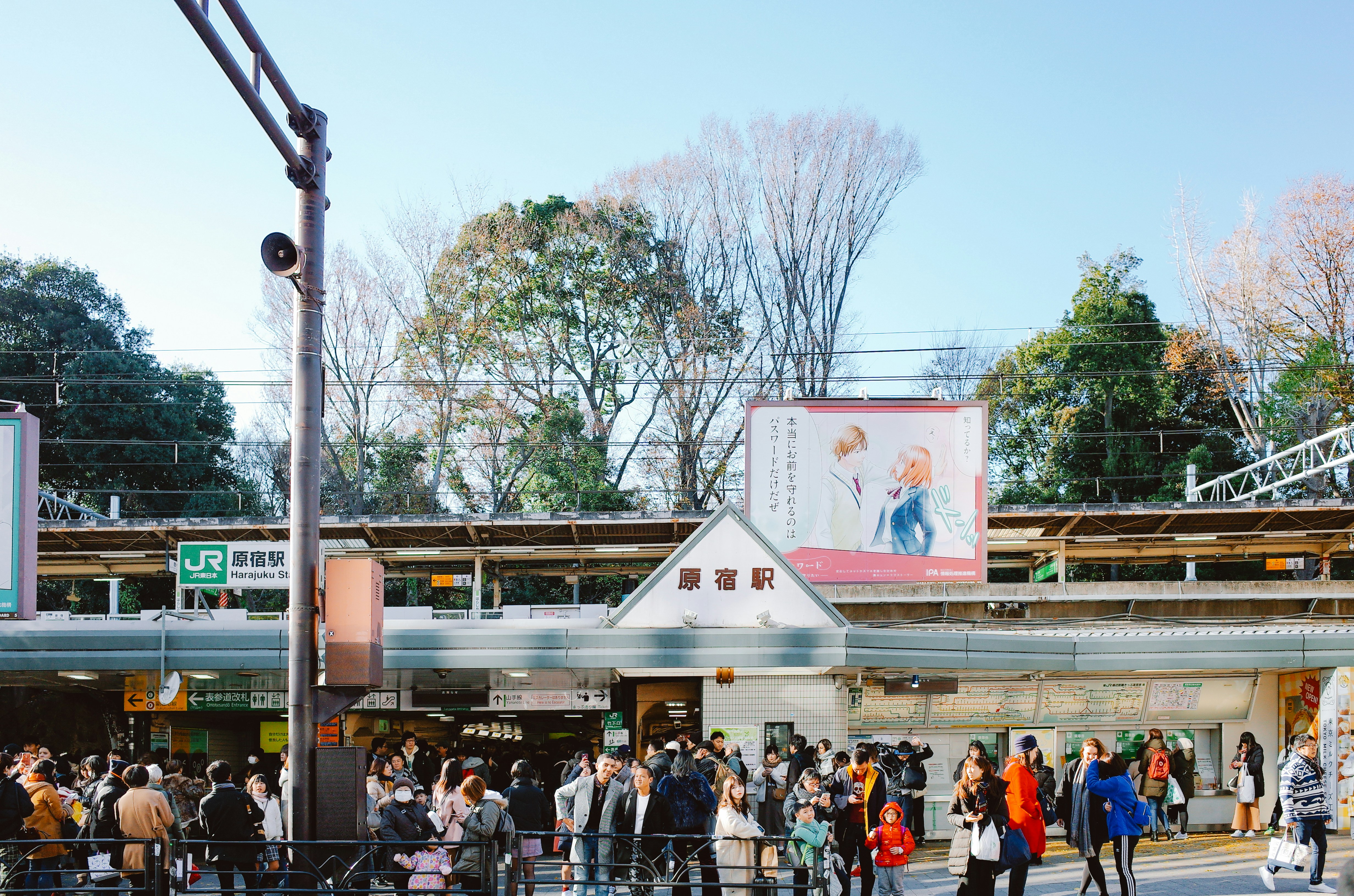 Station Frontage: Crowds Gather at JR Platform Under a Bright Billboard