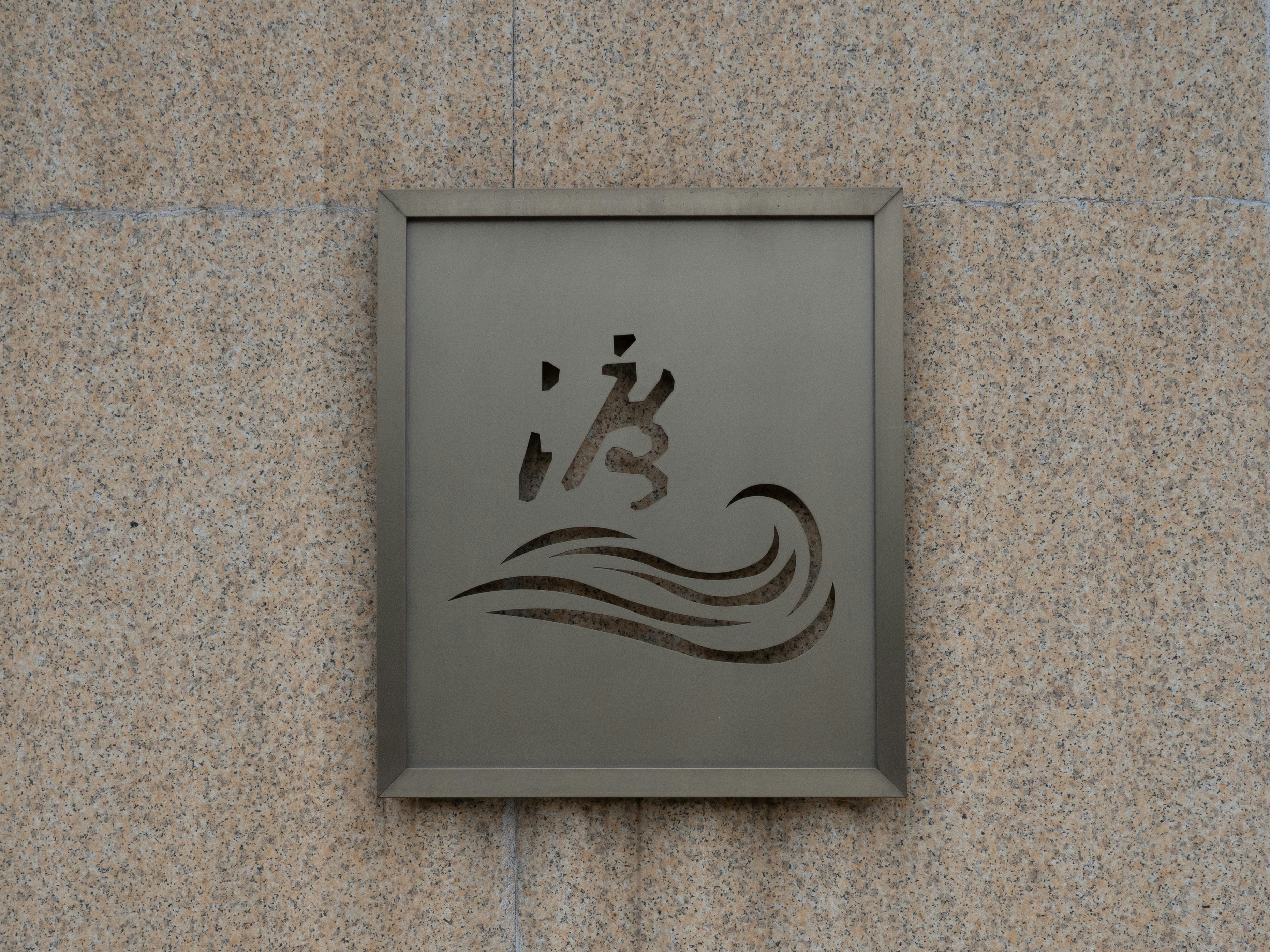 Zen Emblem in Stone: A Framed Metal Panel on Granite