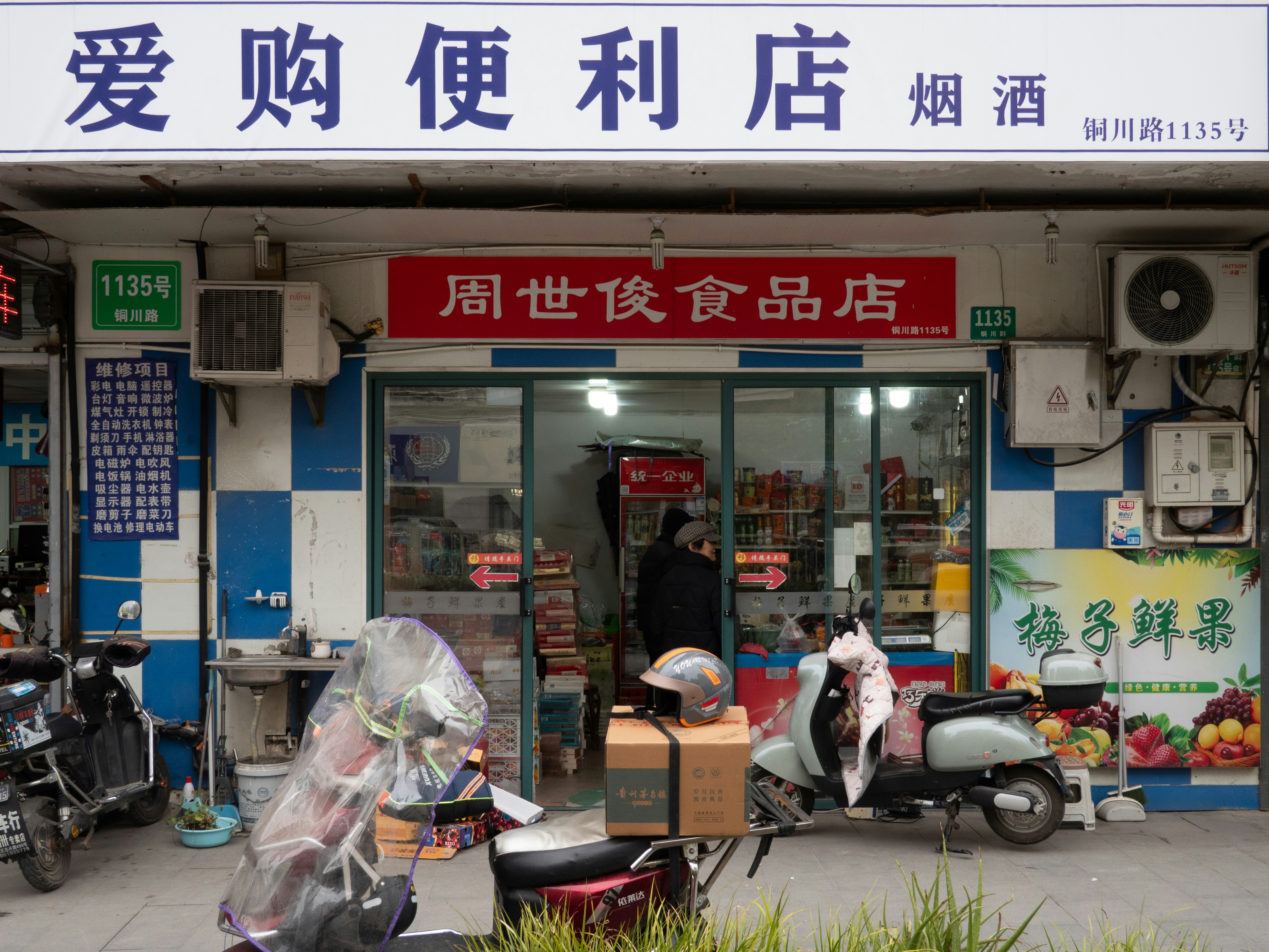 A small convenience store with scooters parked outside