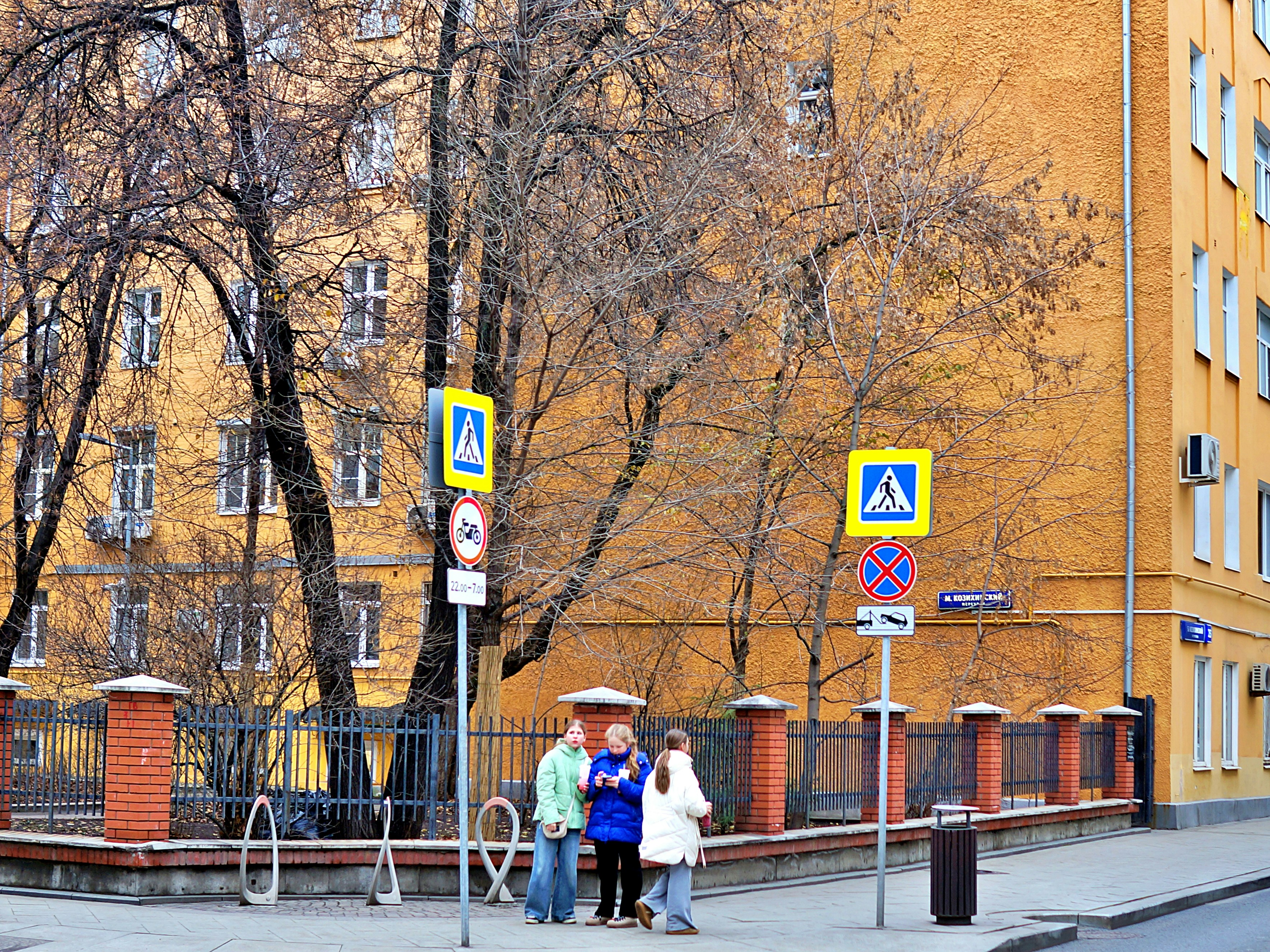 Autumn Street Corner: A Small Group Beneath a Golden Facade