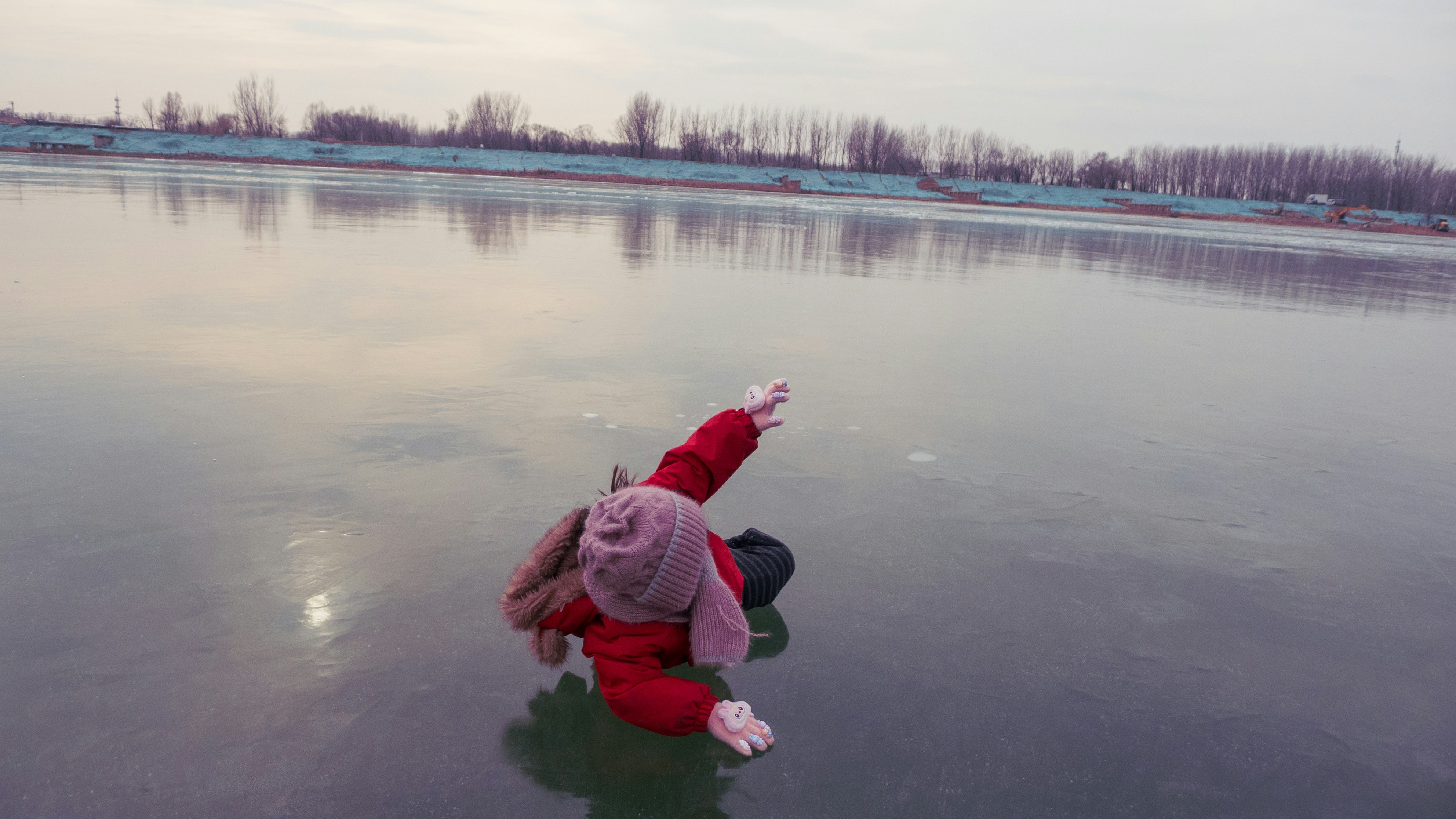 A person in a red coat on a frozen lake.