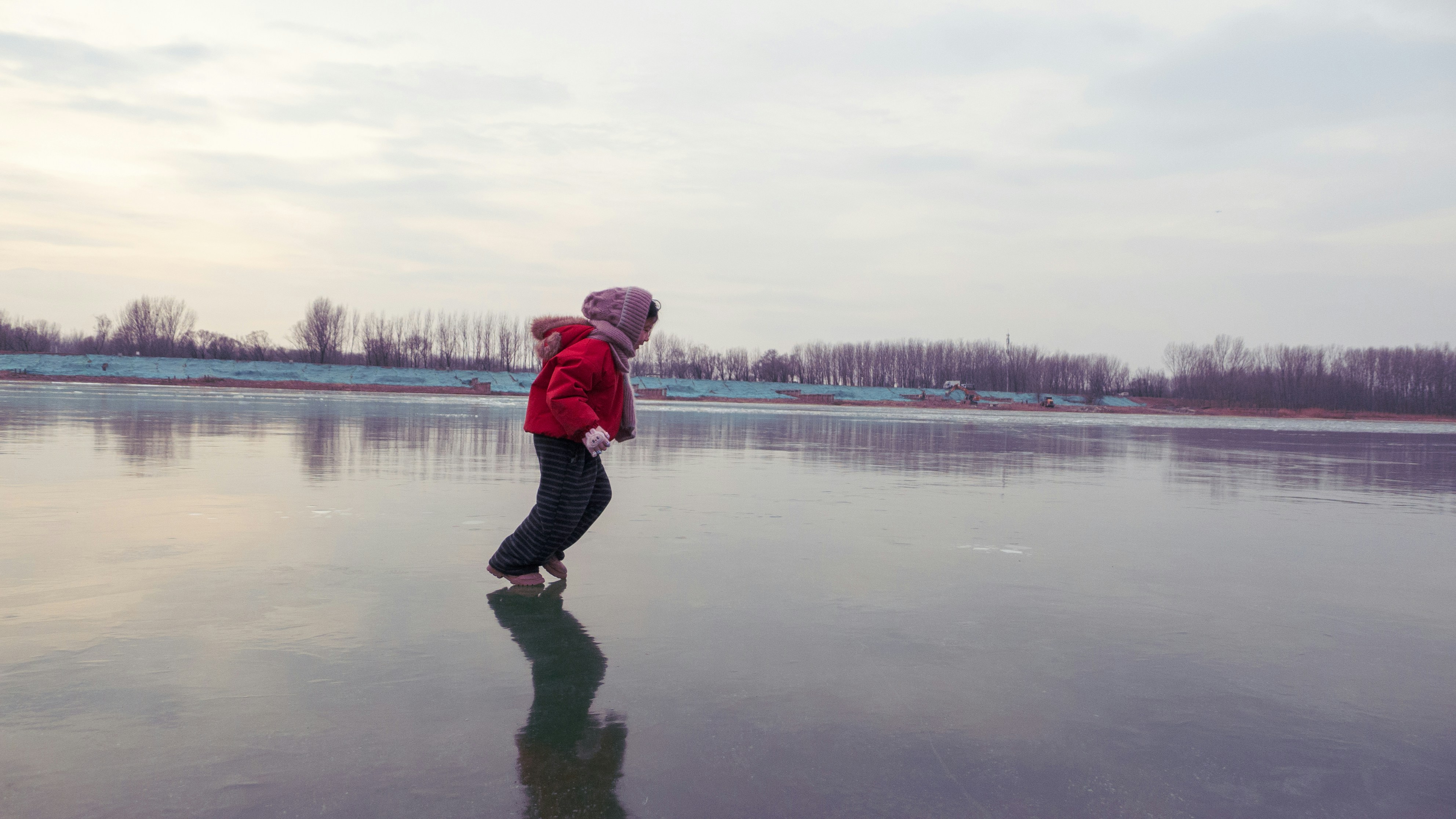 Child ice skating on a frozen lake