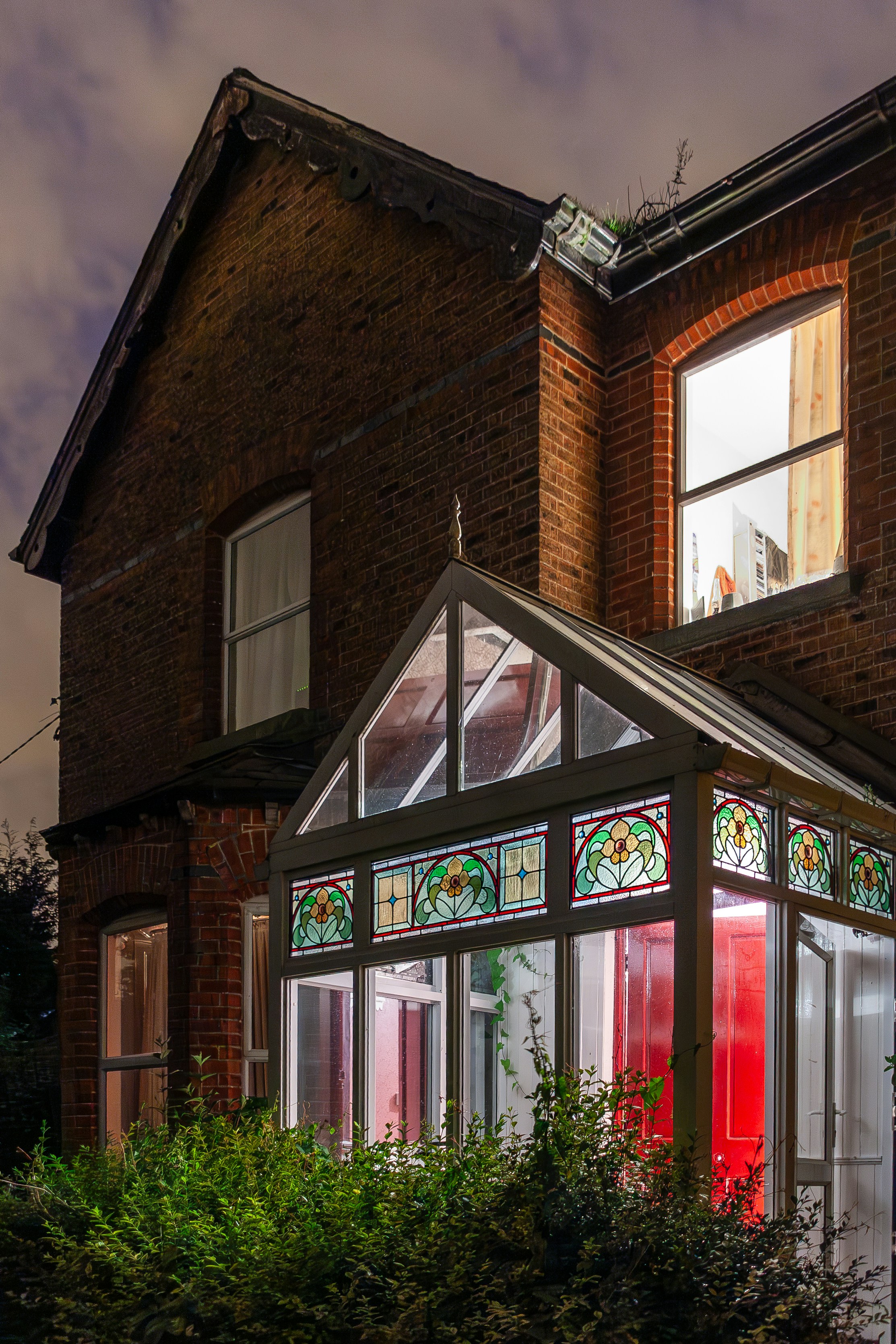 Glasshouse at Dusk: Stained Light in a Brick Annex