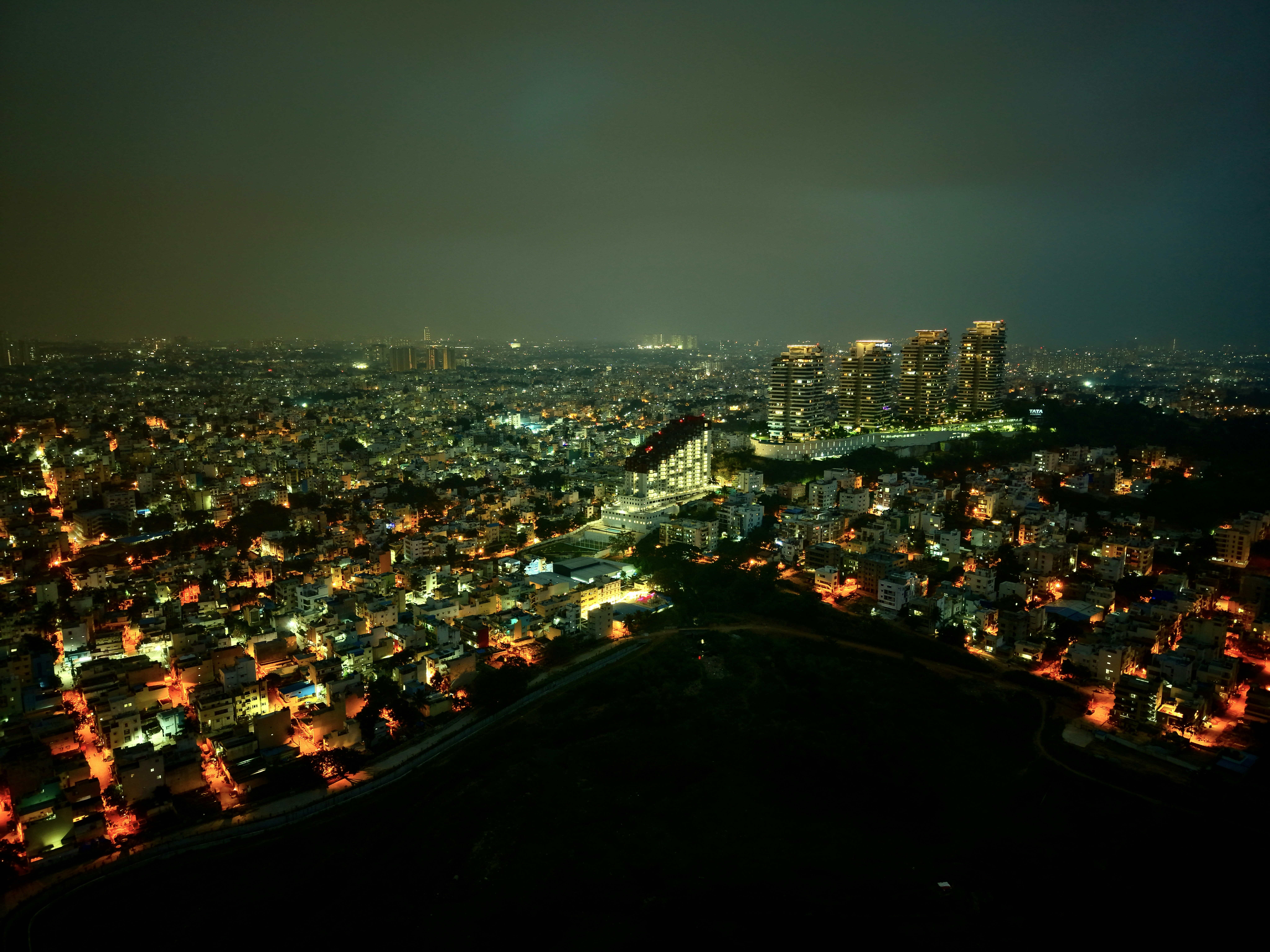 aeria night view of modern high-rise buildings overlooking a brightly lit urban landscape