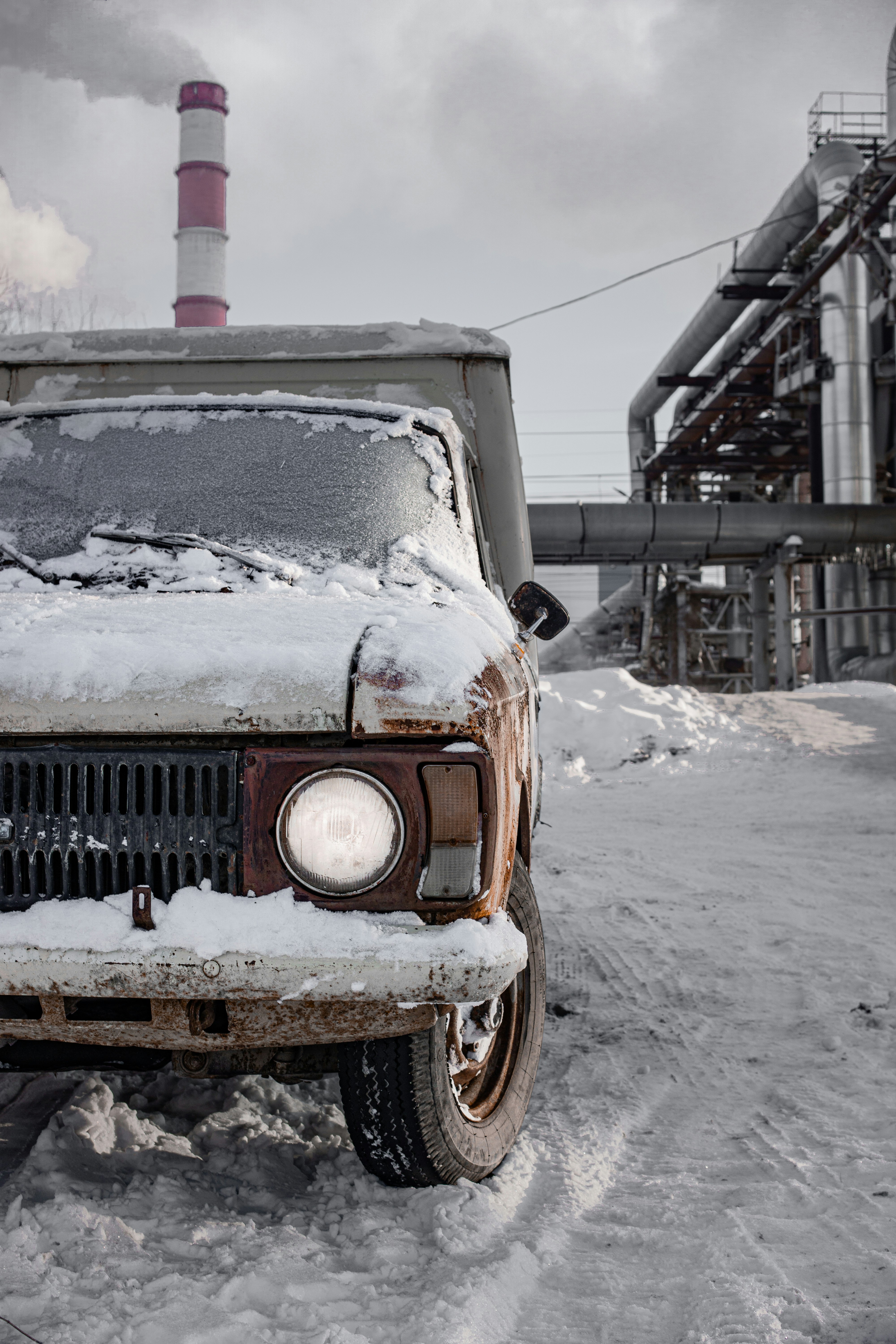 Snowbound Classic: A Rusted Pickup Guarded by Industrial Echoes