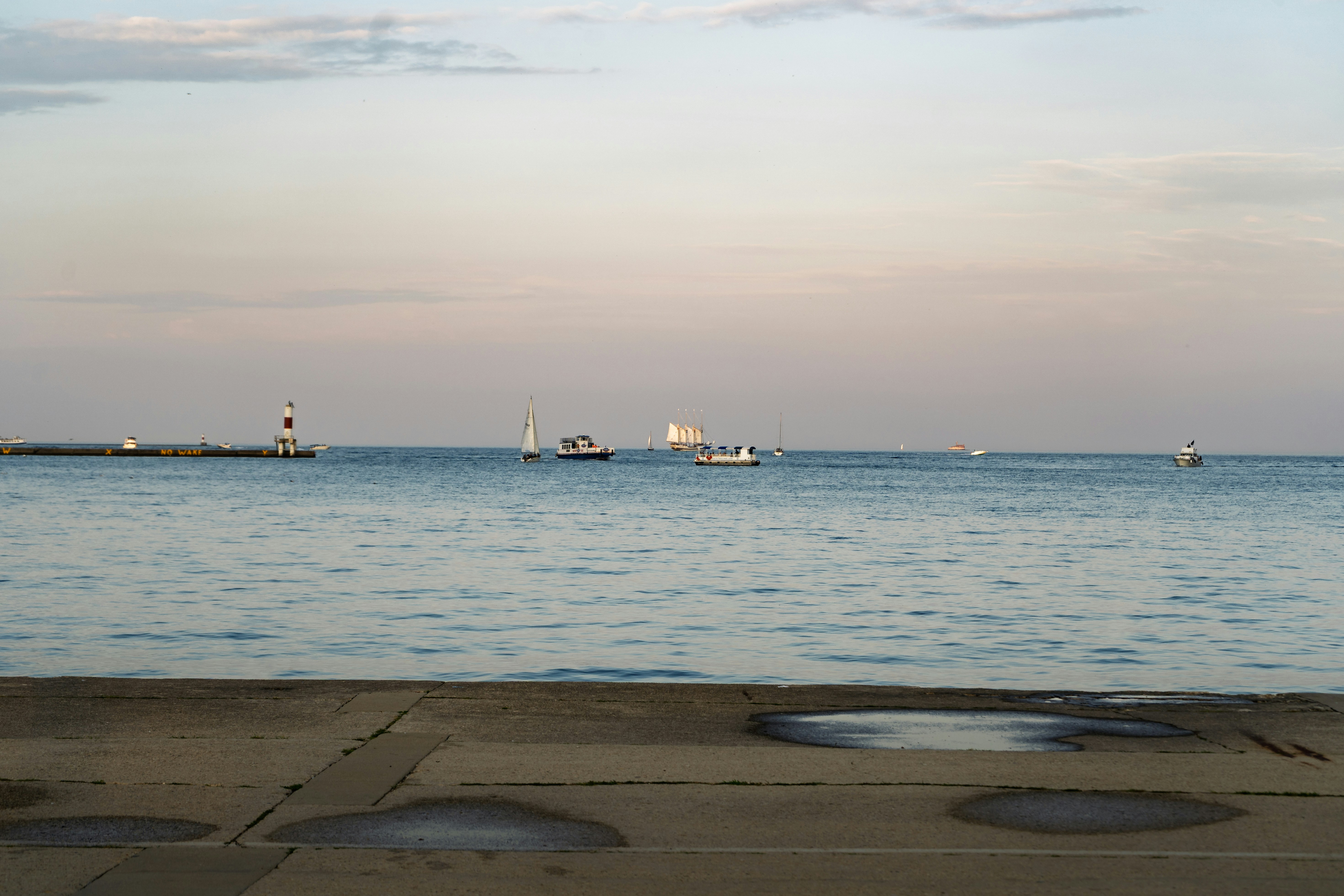 Horizon at the Quiet Sea: Boats Drift Under a Pale Sky
