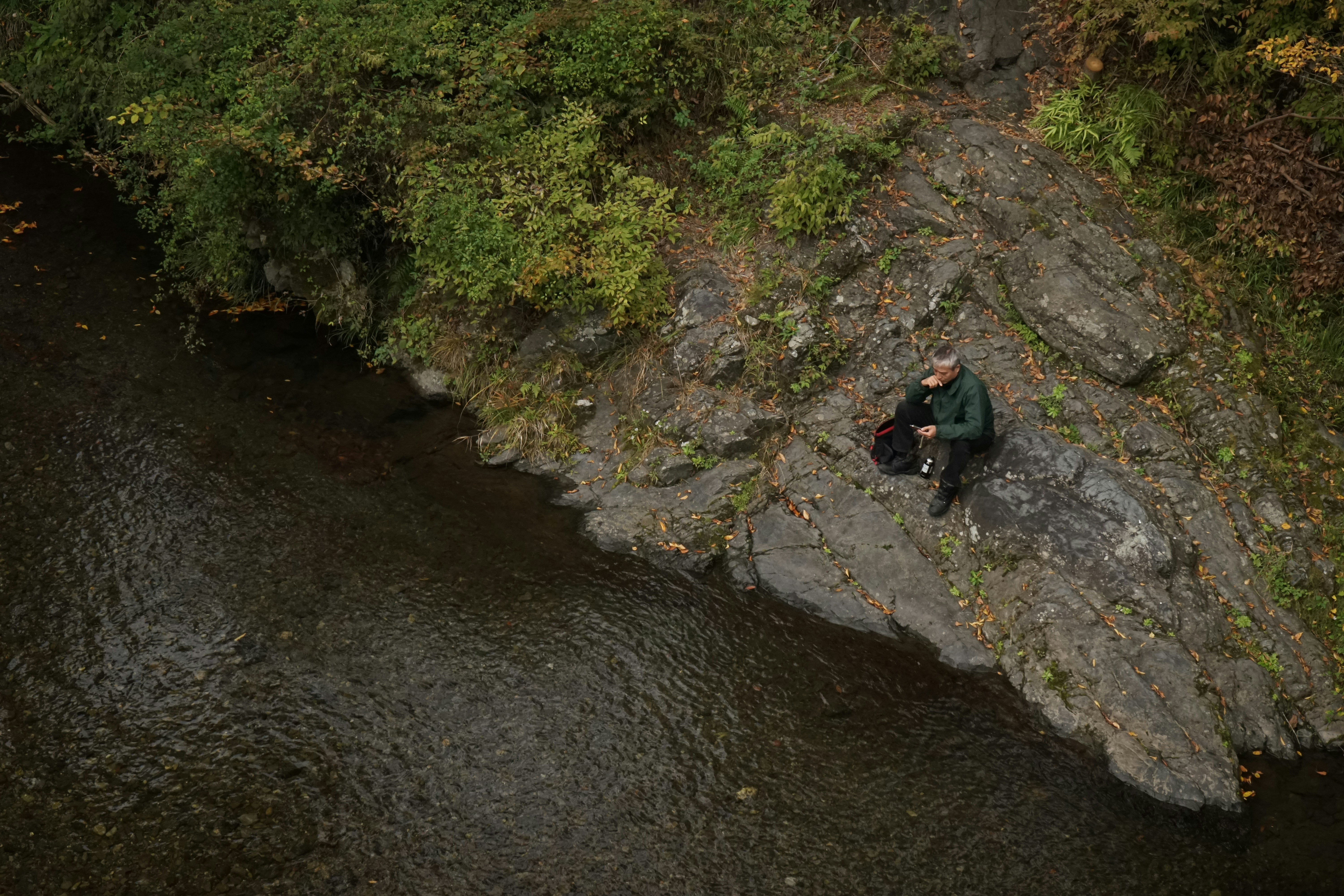 Escarpment Quiet: A lone climber by the riverbank