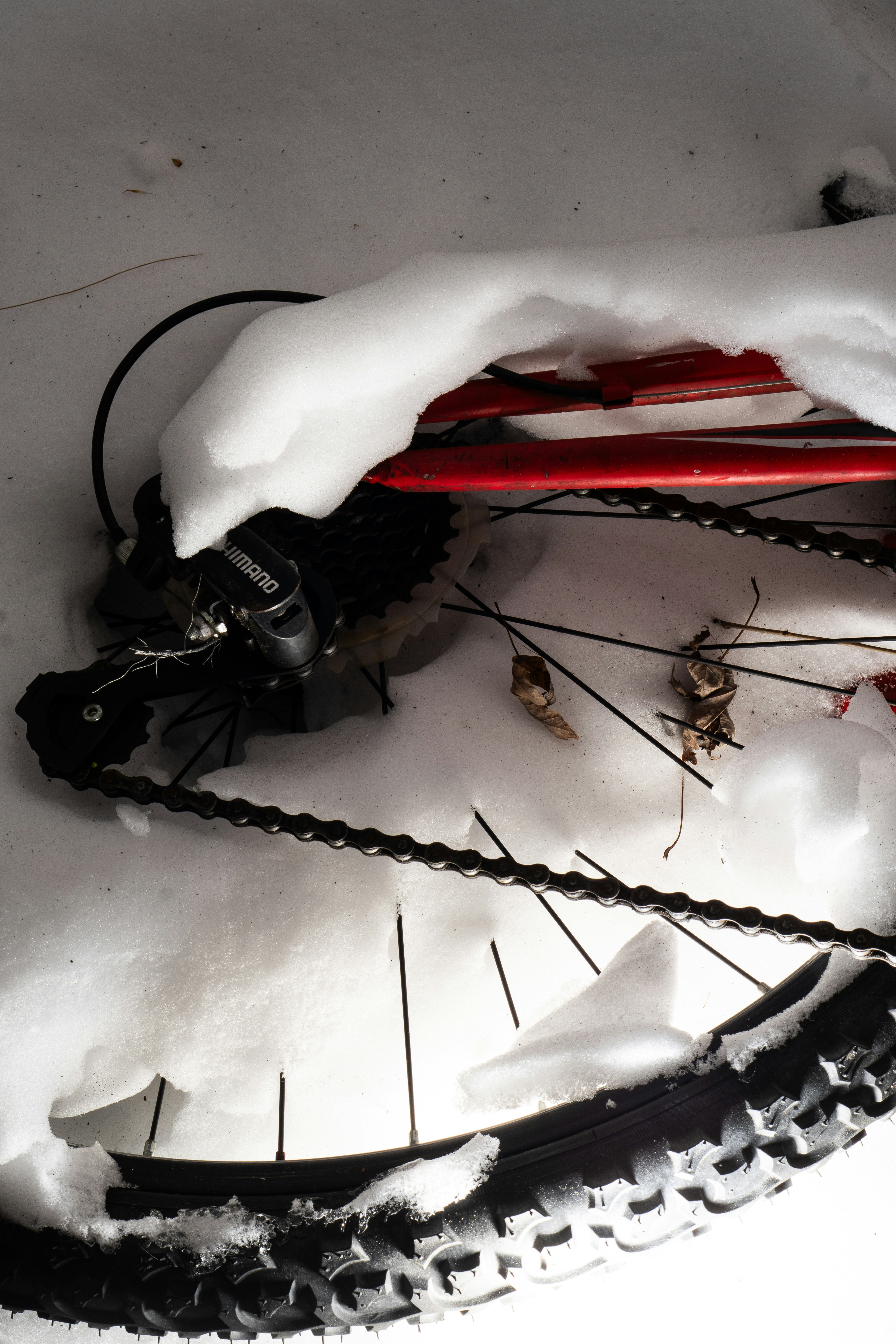 Snow-Covered Bike Chain and Gear Hidden Under White Drift