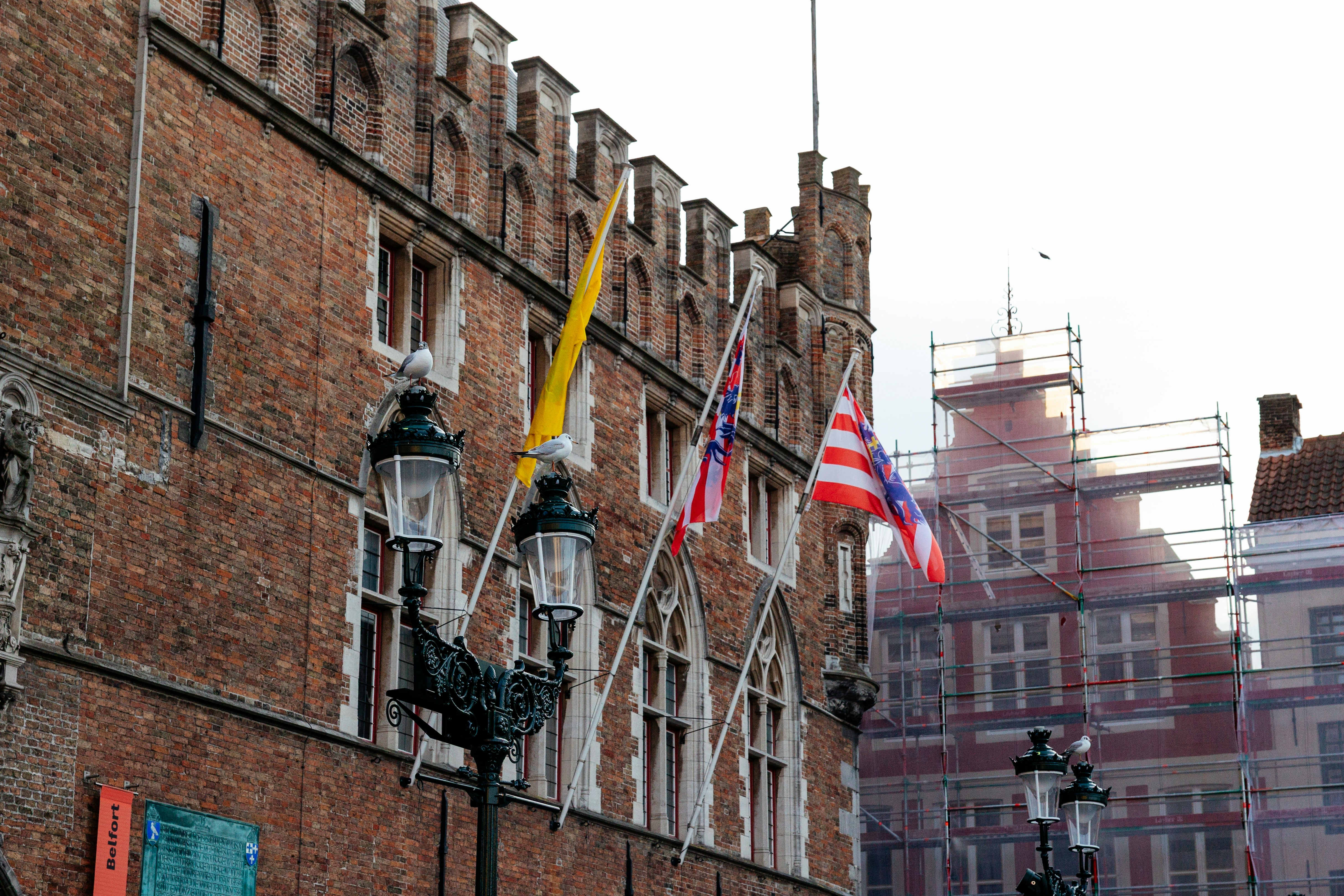 Flagged Facade: Flags and Gothic Windows on a Brick Town Hall