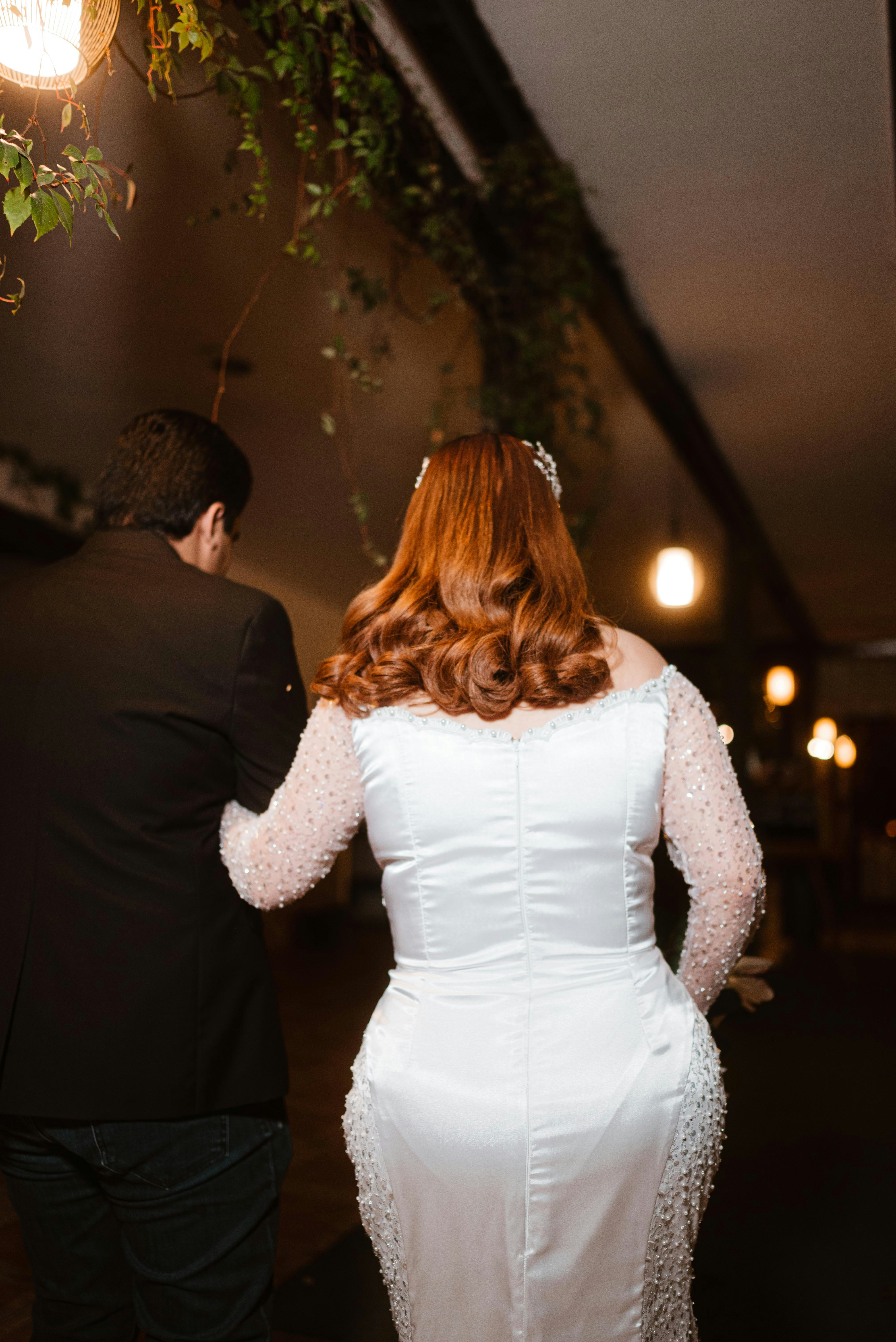 Backlit vows: a bride in white under soft lantern glow