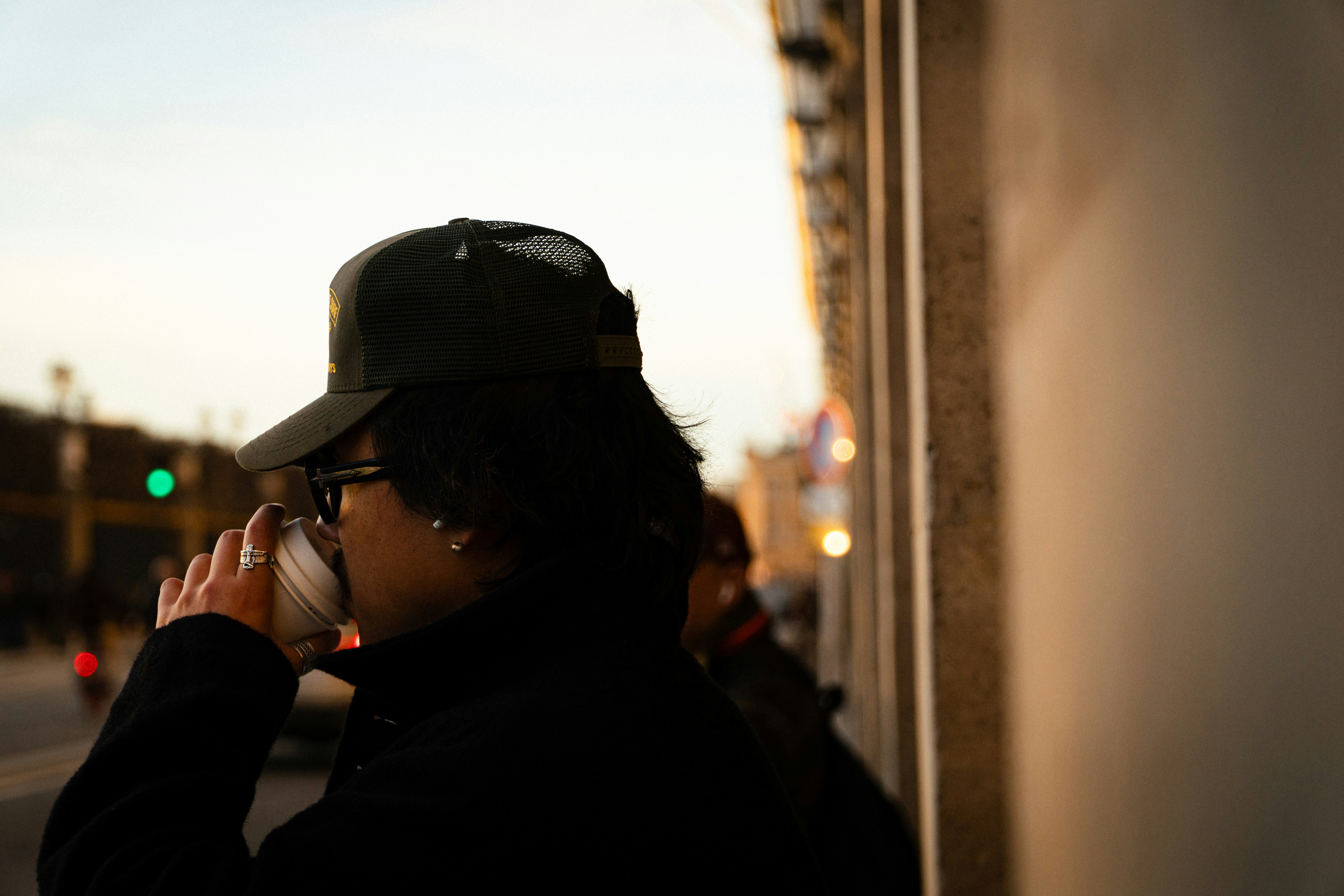 Late-afternoon confidant: a lone figure on a phone against a sunlit street