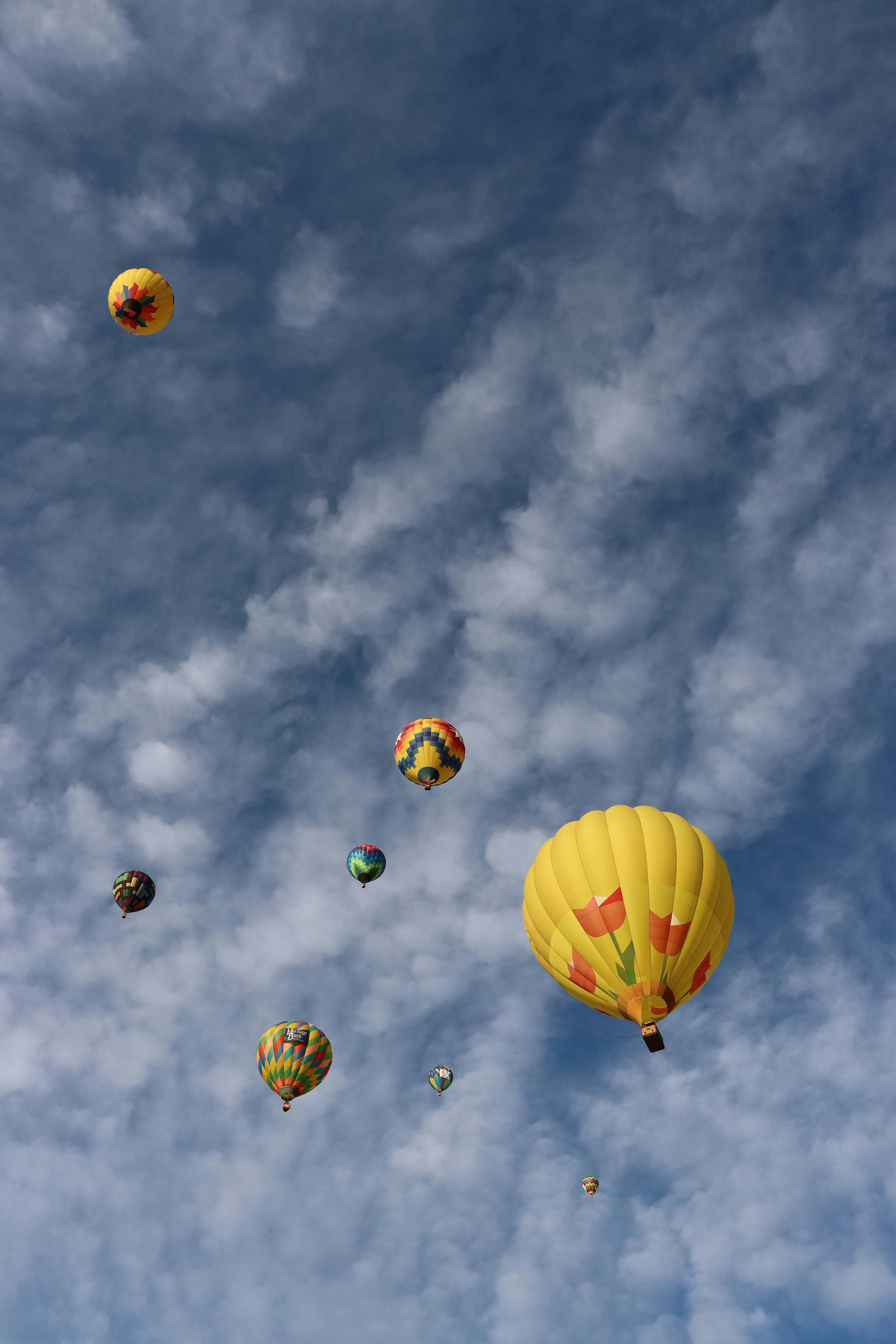 Floating Fire: A Parade of Balloons Against a Brush-Stroked Sky