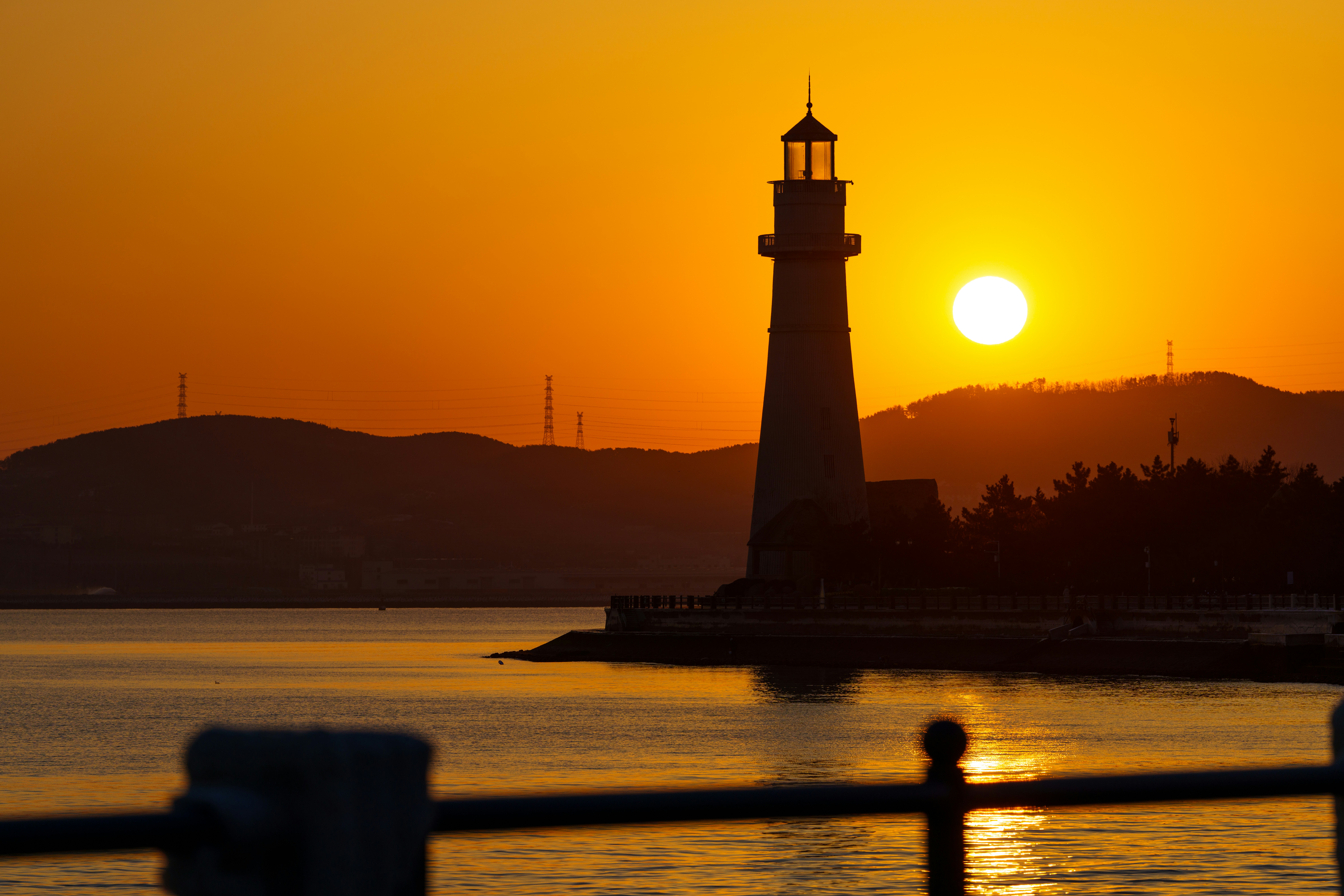 Sunlit Beacon: A Seaside Lighthouse Against a Golden Dusk