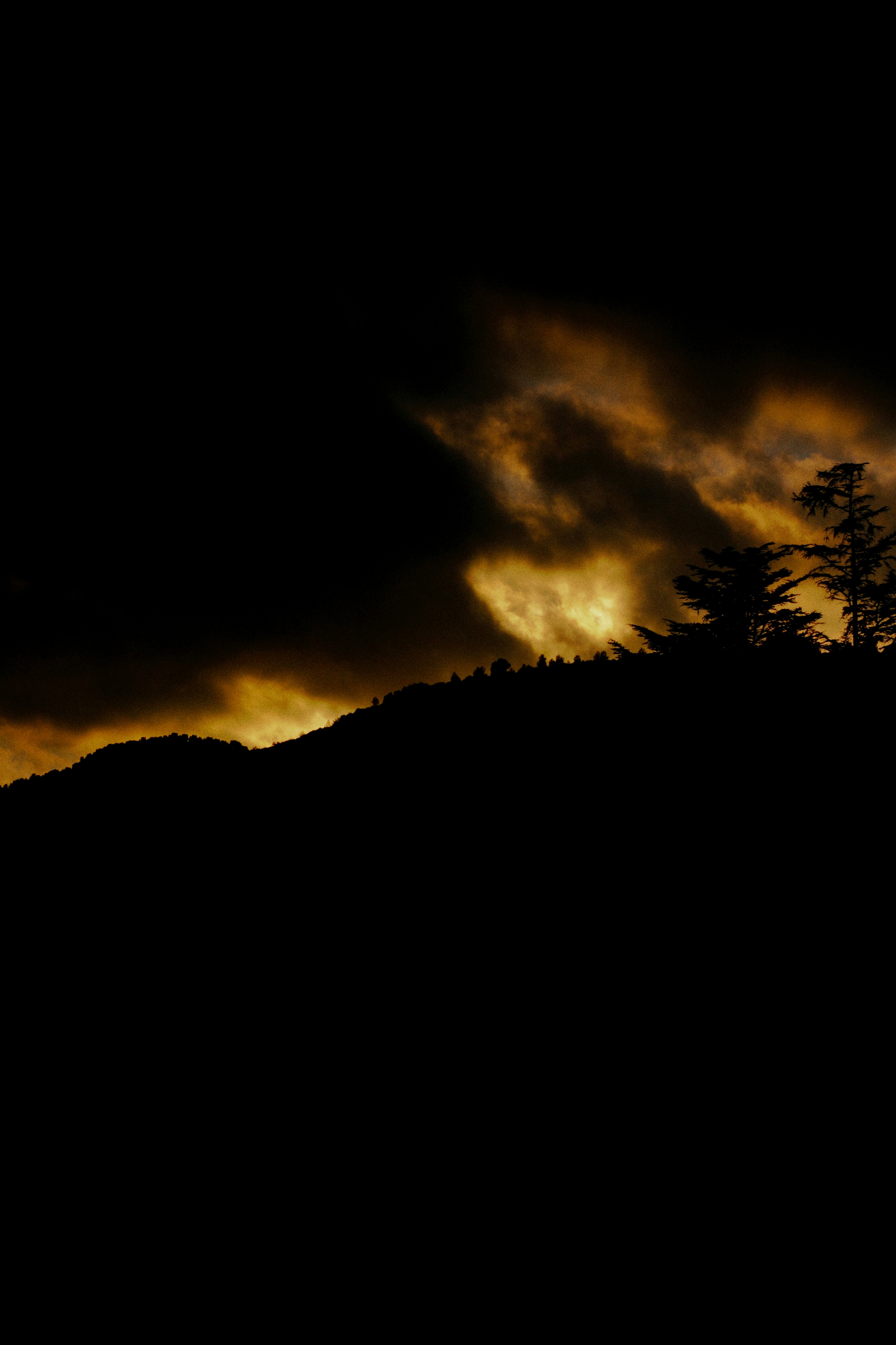 Silhouette on the Ridge as Fiery Clouds Fold Over the Horizon