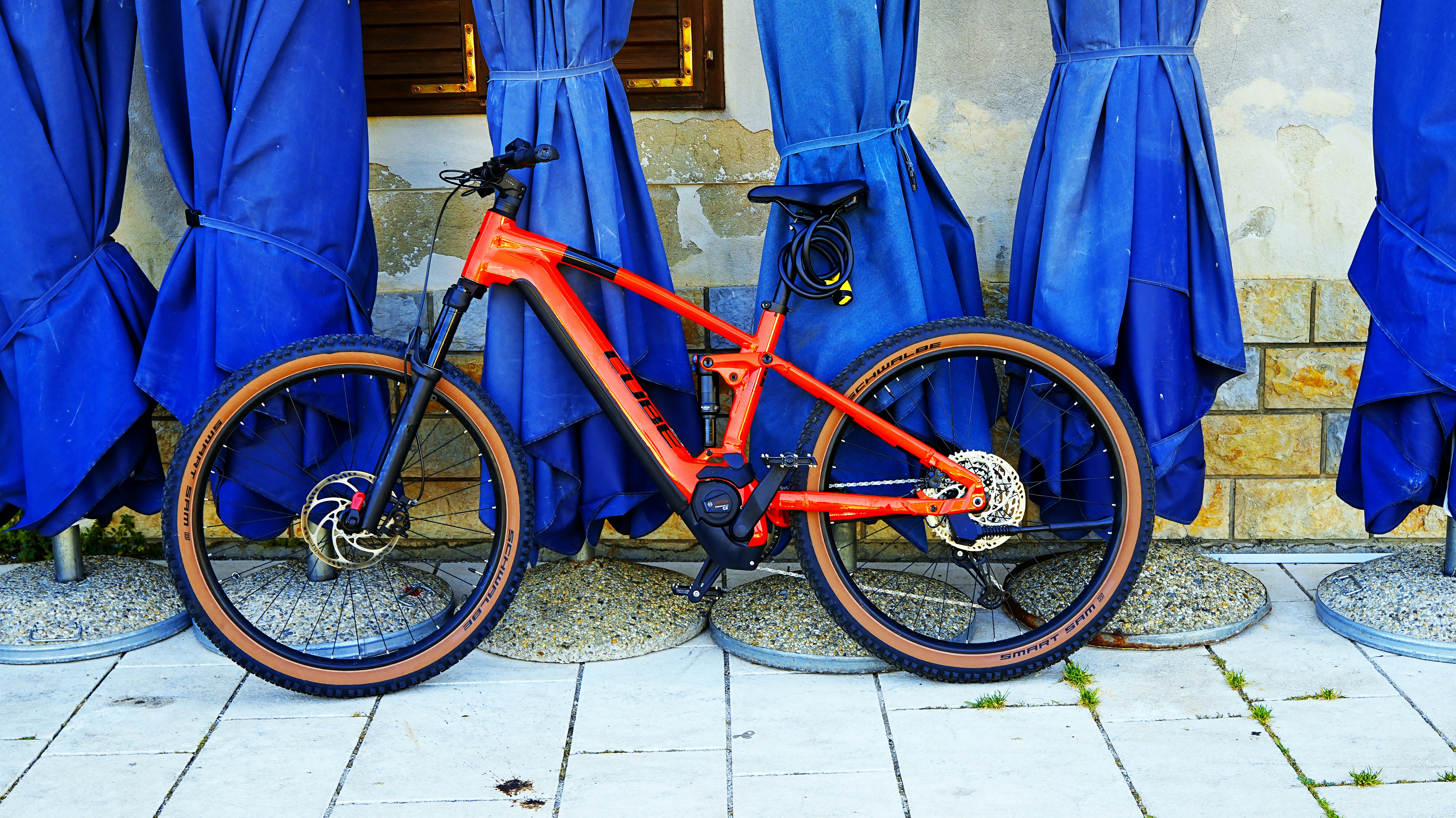 Red Mountain Bike Resting Against a Blue Curtain Wall