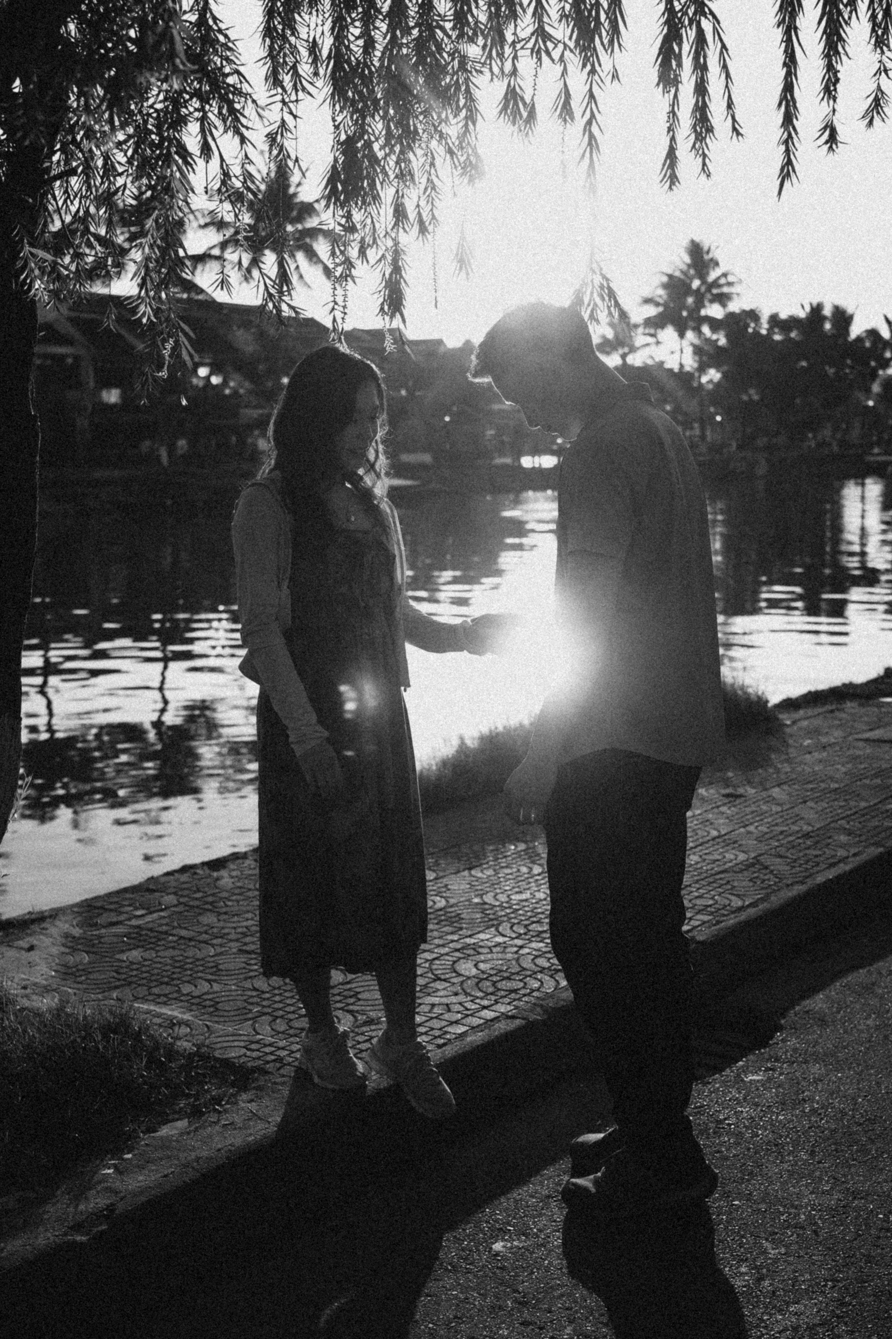 Backlit Silhouettes by the River: Quiet Moment at Dusk