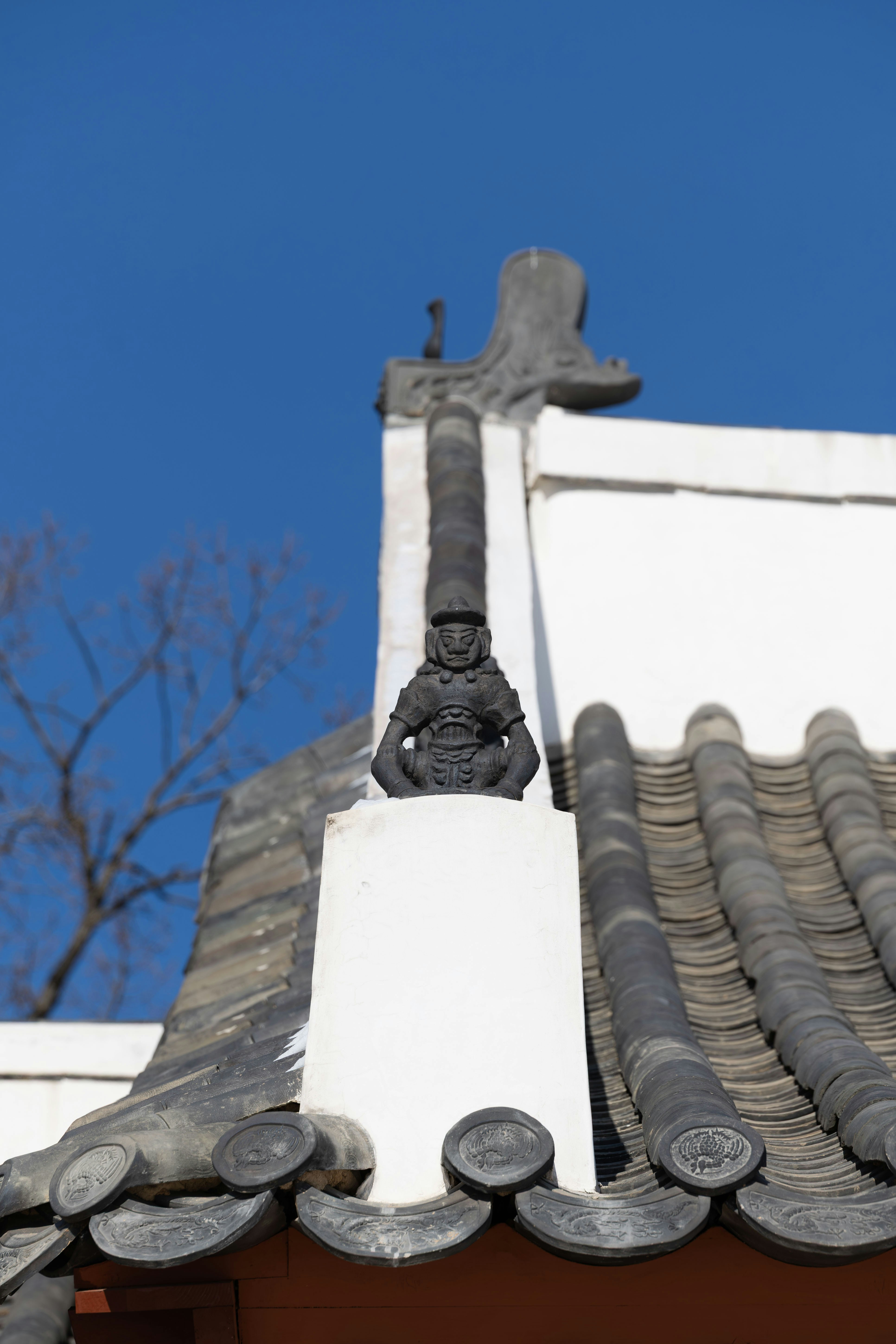 Architectural Sentinel: A Mini Statue Among Cerulean Sky