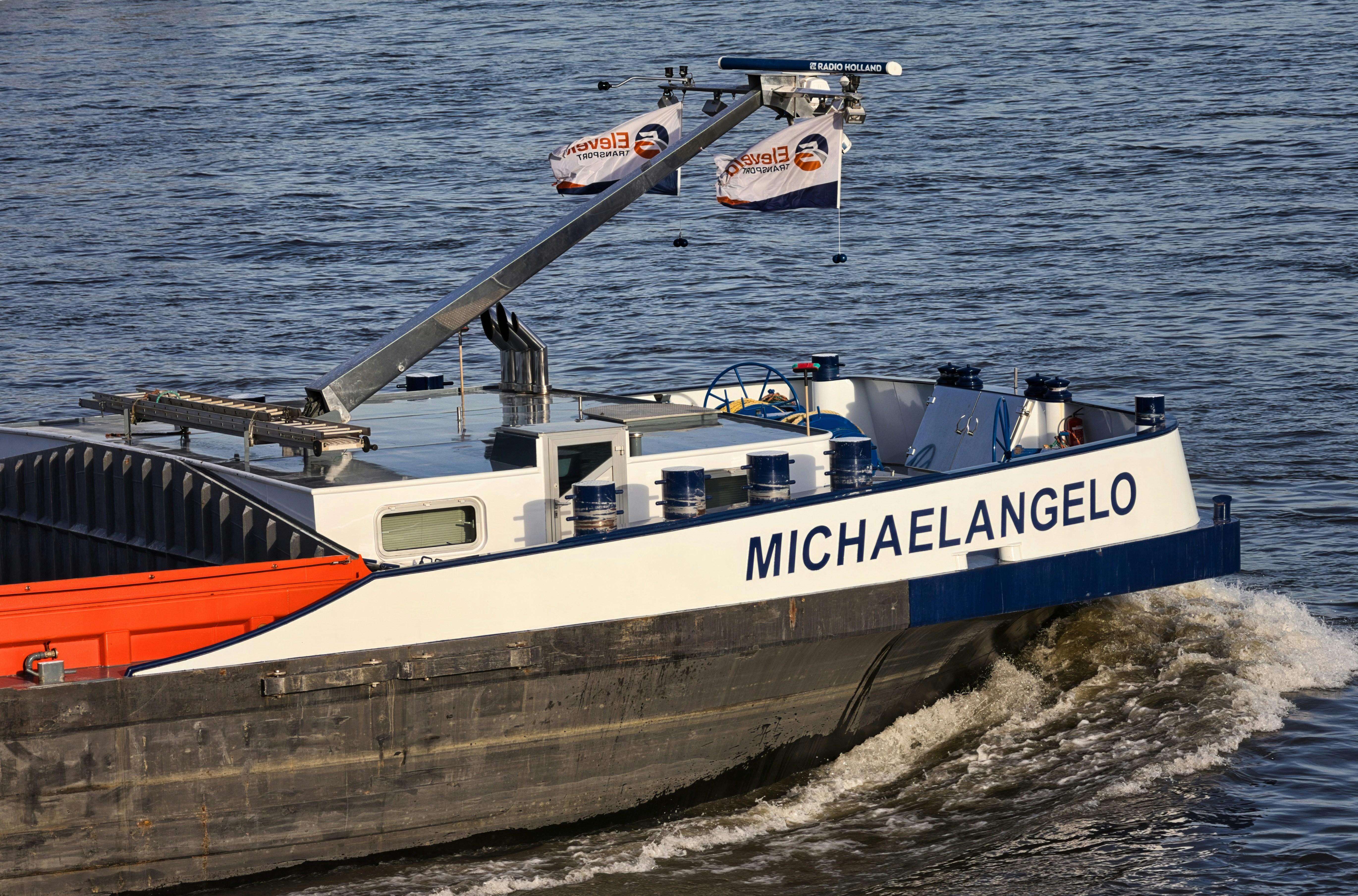 Name on the Bow: A Freight Cutter Slices Through Glimmering Water