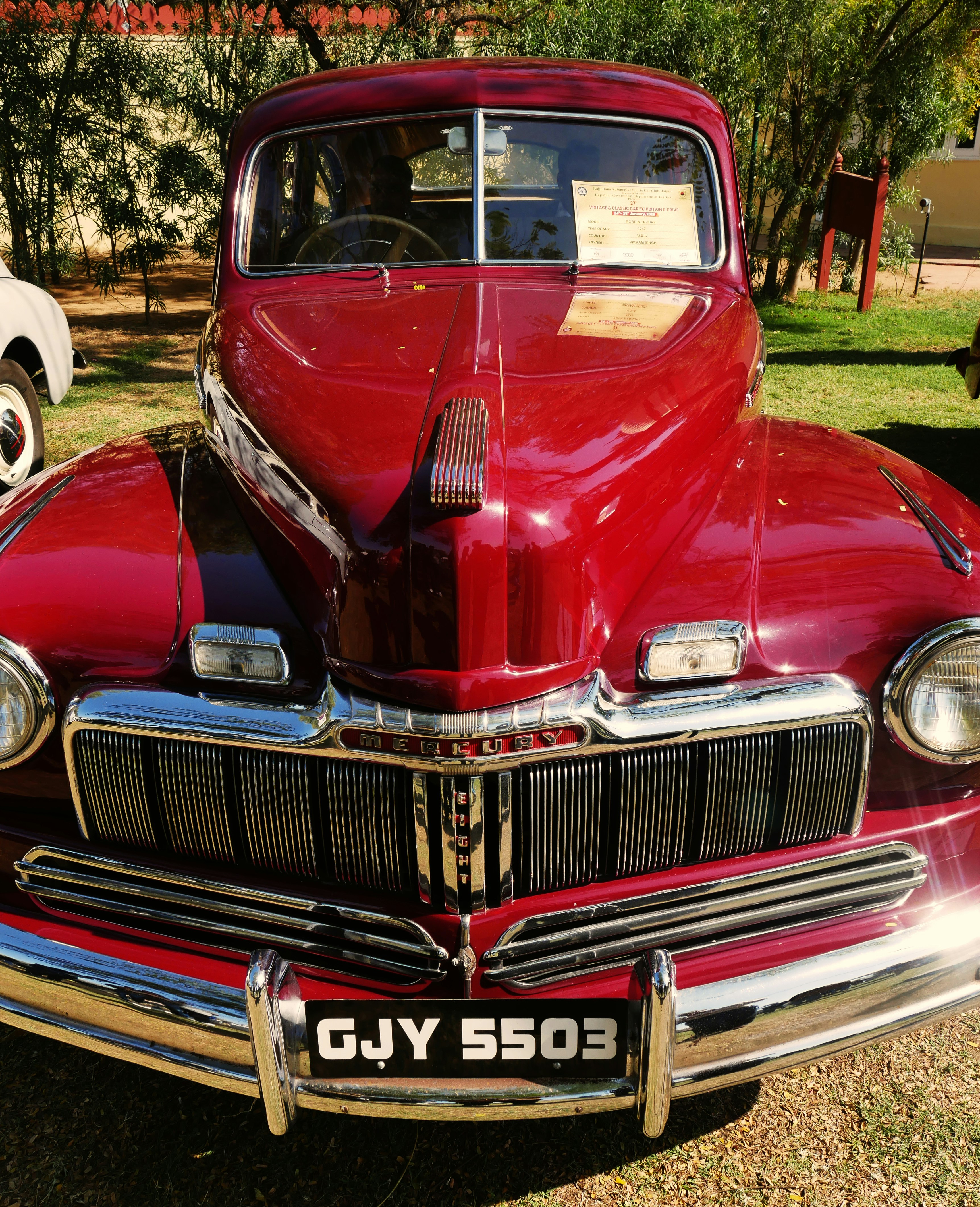 Front View of a Shiny Vintage Crimson Chevrolet Under Warm Sun