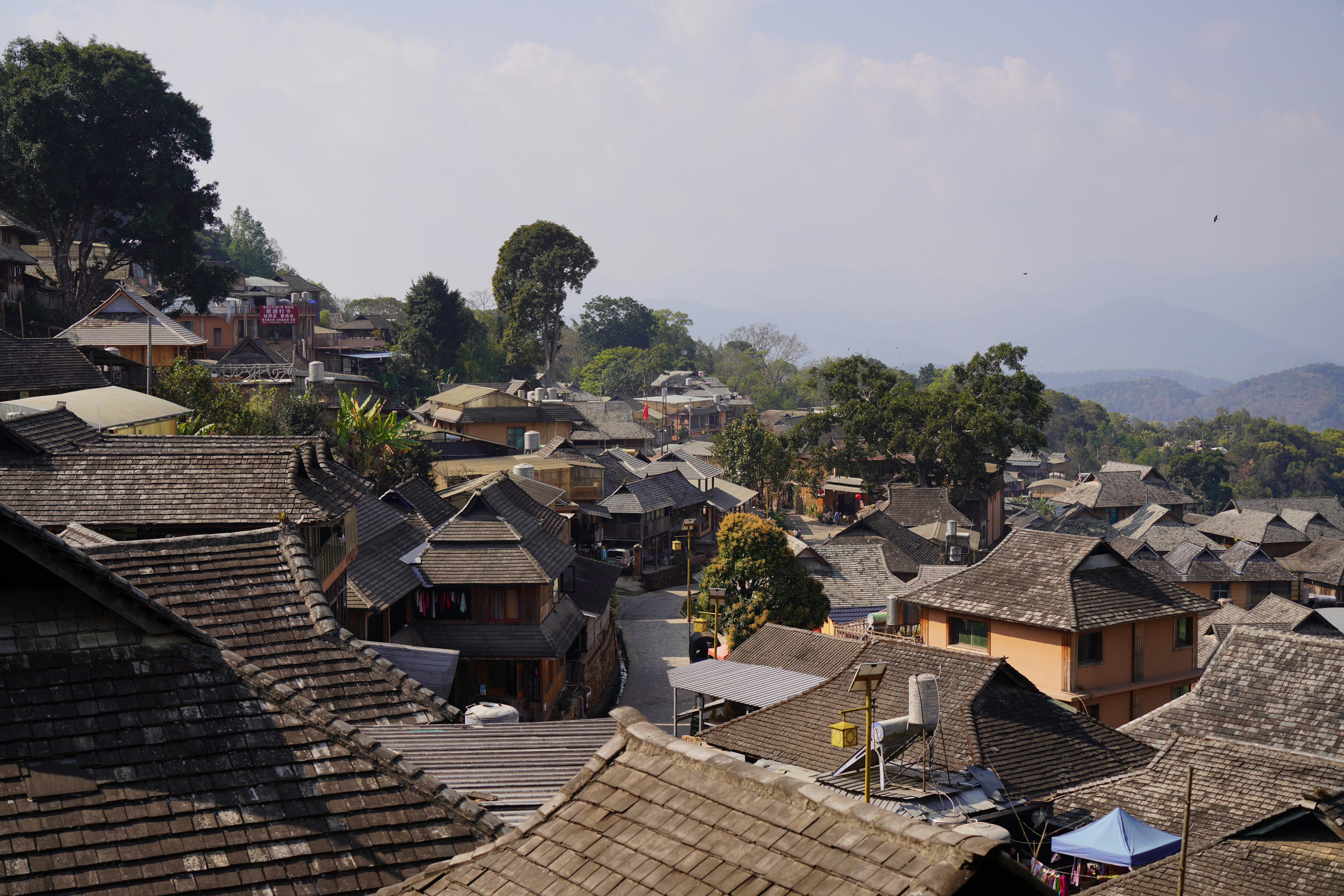 Rooftop Mosaic: A hillside village under a calm afternoon