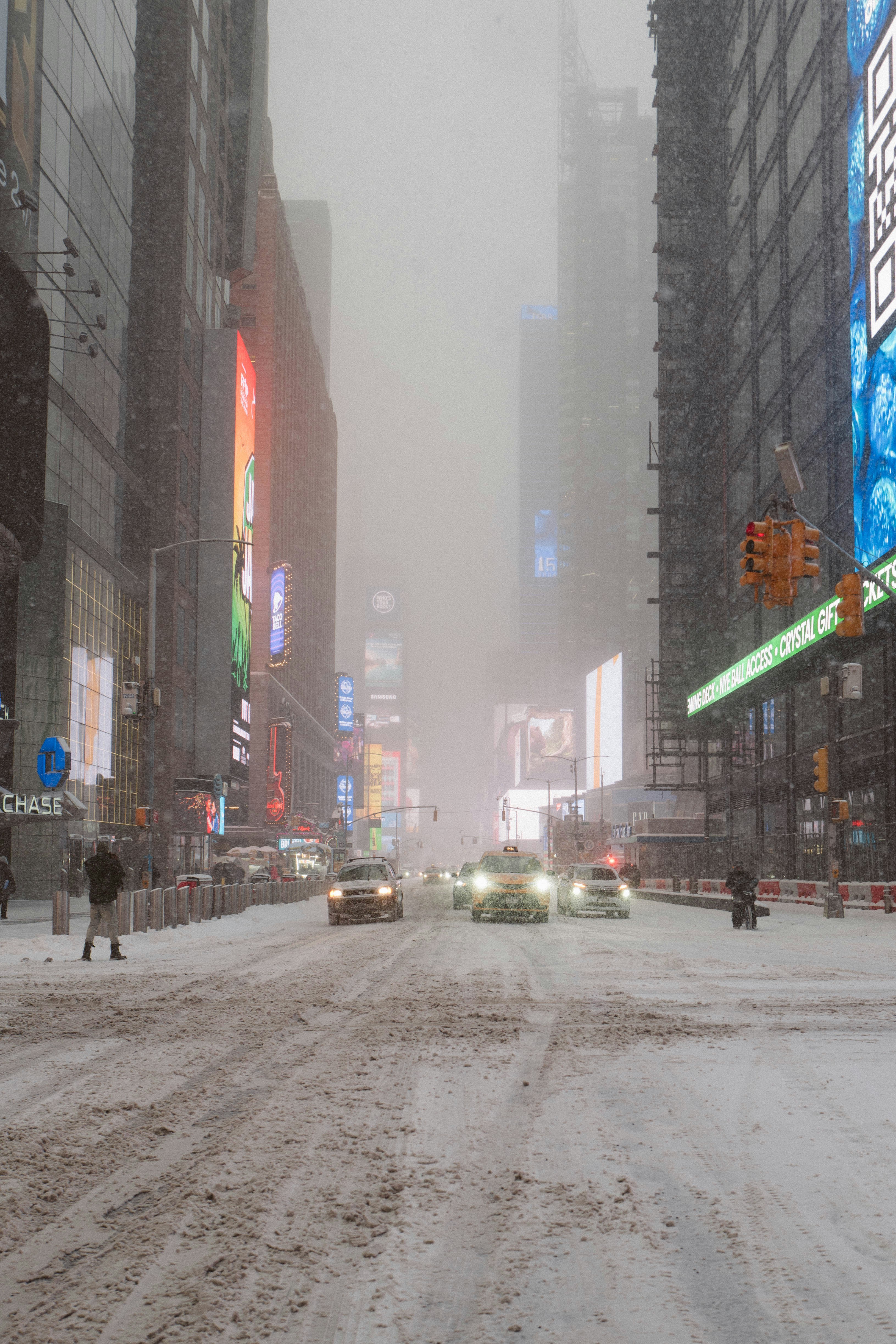 Snowy Broadway Silence: Cars and Pedestrians in a Blurred Night