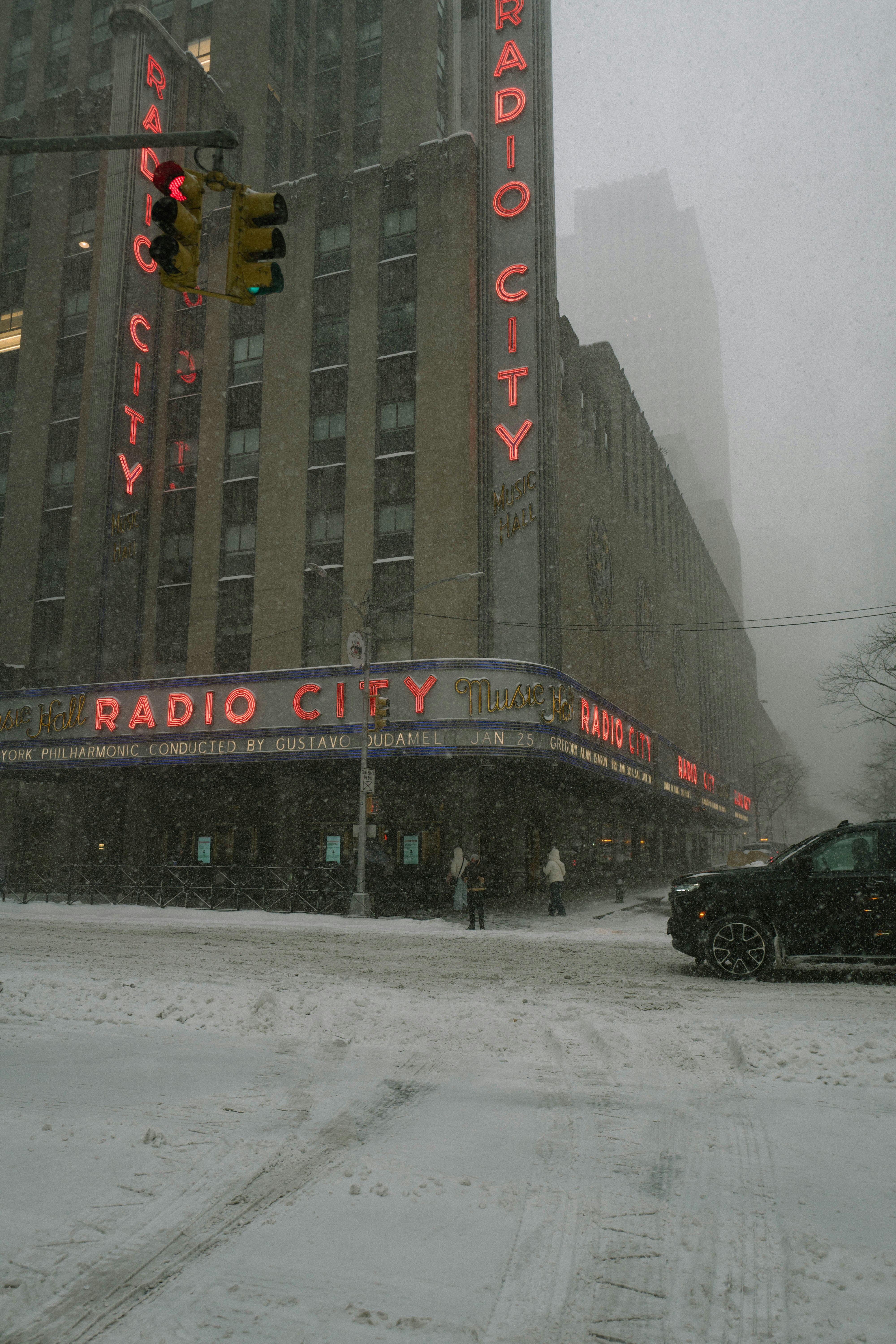 Neon Broadway in Snow: Theater Signage Under Blurred Snowfall